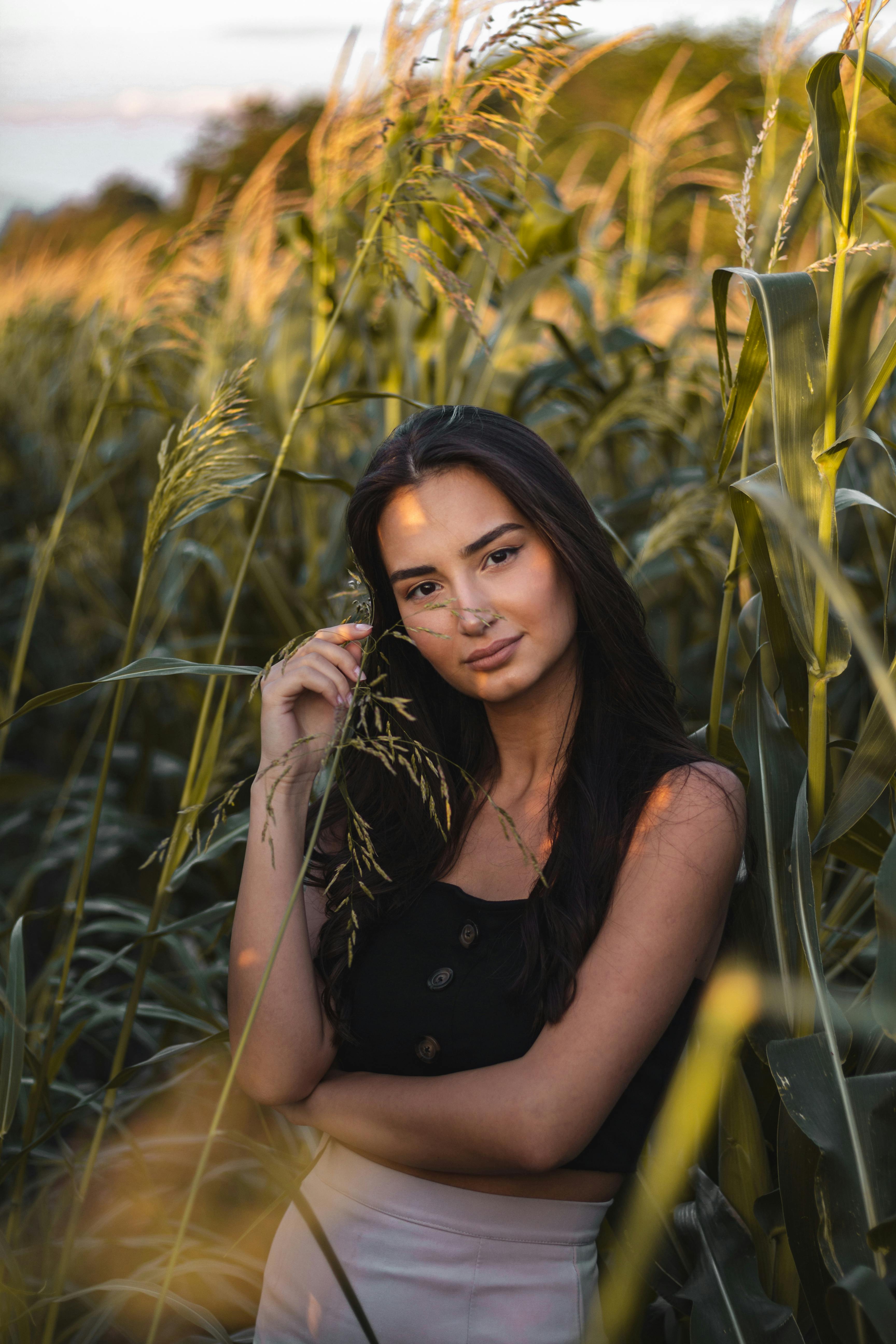 Pretty Woman Wearing Crop Top and Denim Shorts Standing Near Plants ...