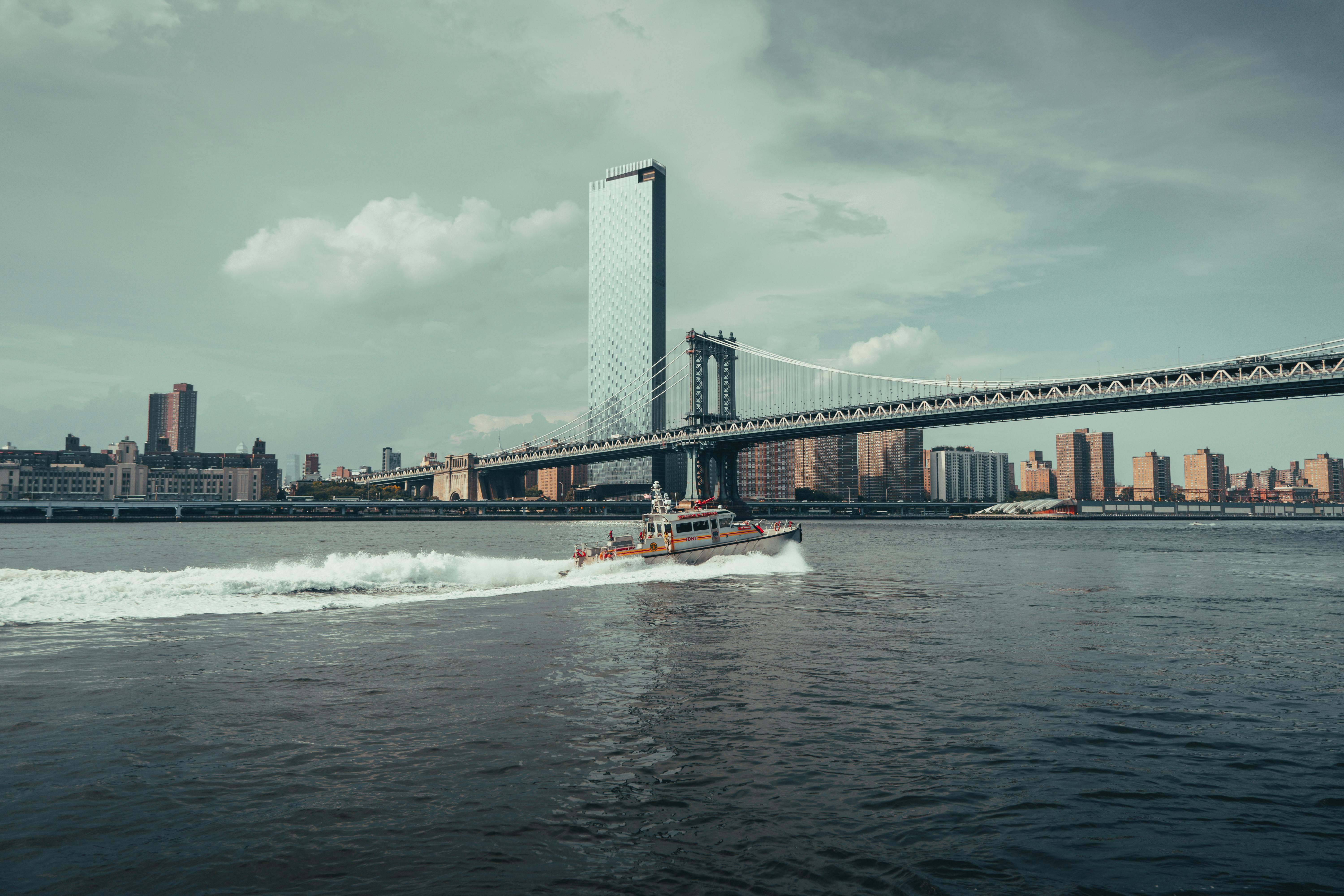A Boat Sailing on the Sea Under the Bridge · Free Stock Photo