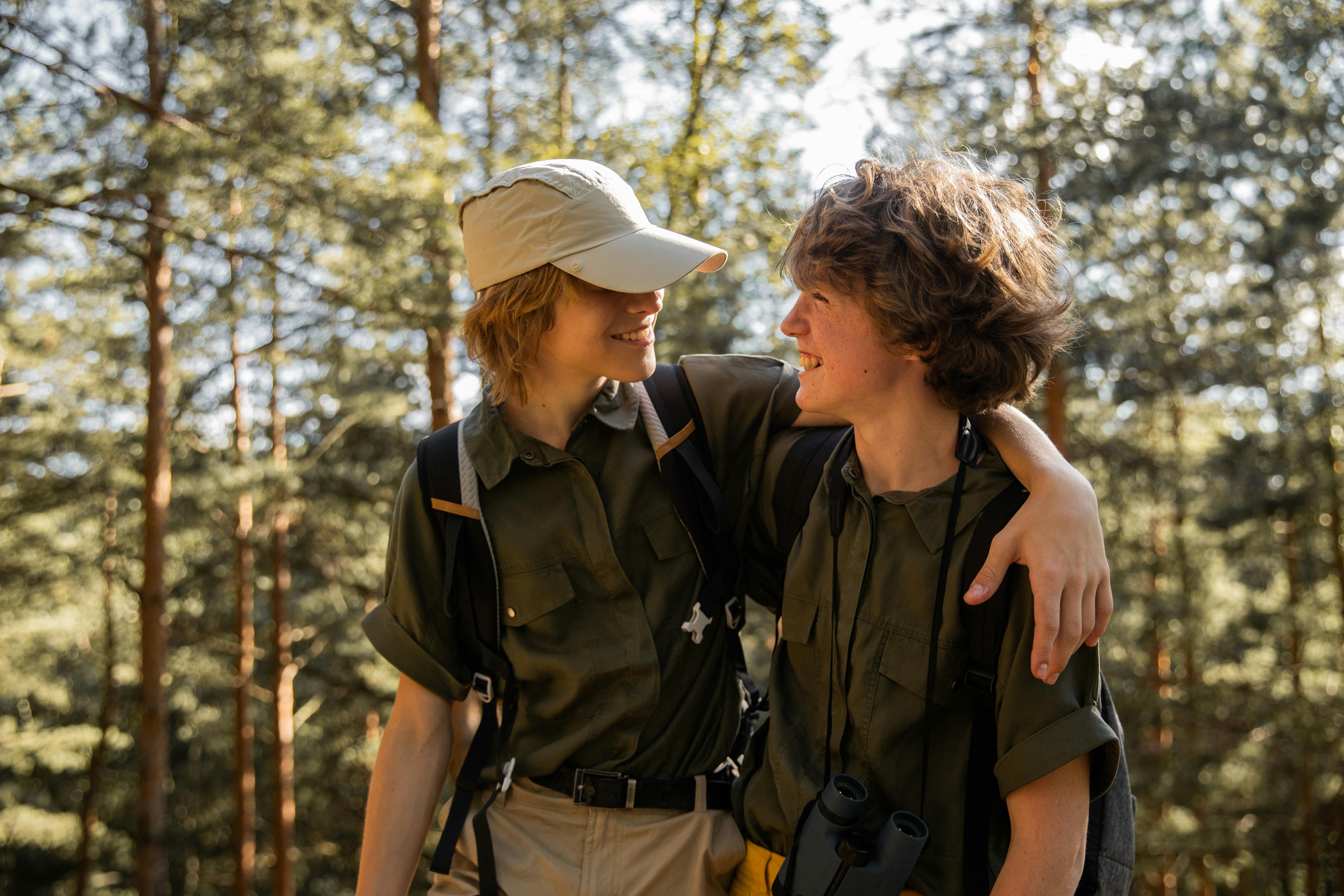 Smiling Boy Scouts Hugging in Forest · Free Stock Photo