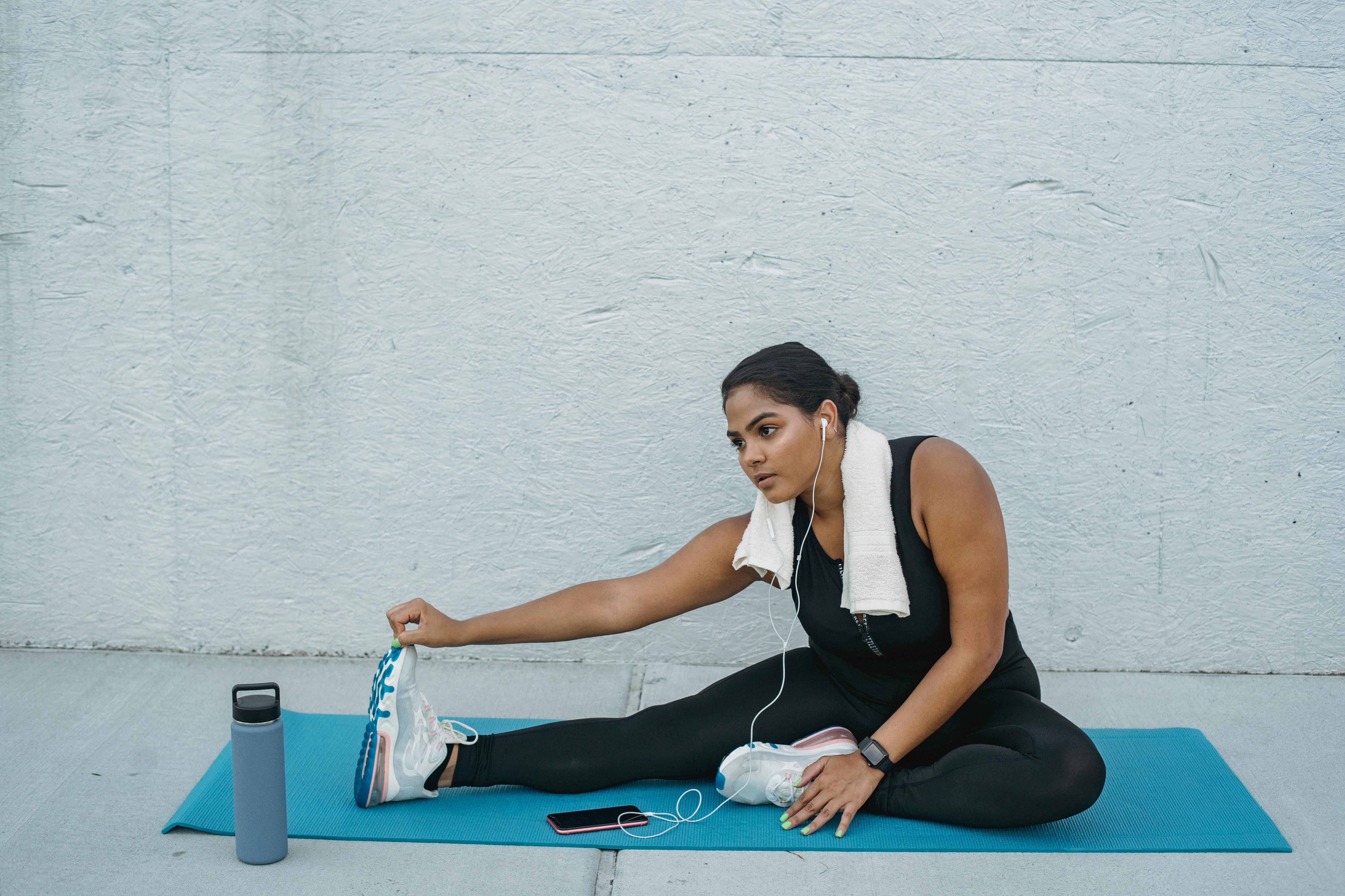 Brunette Woman Stretching on Yoga Mat · Free Stock Photo