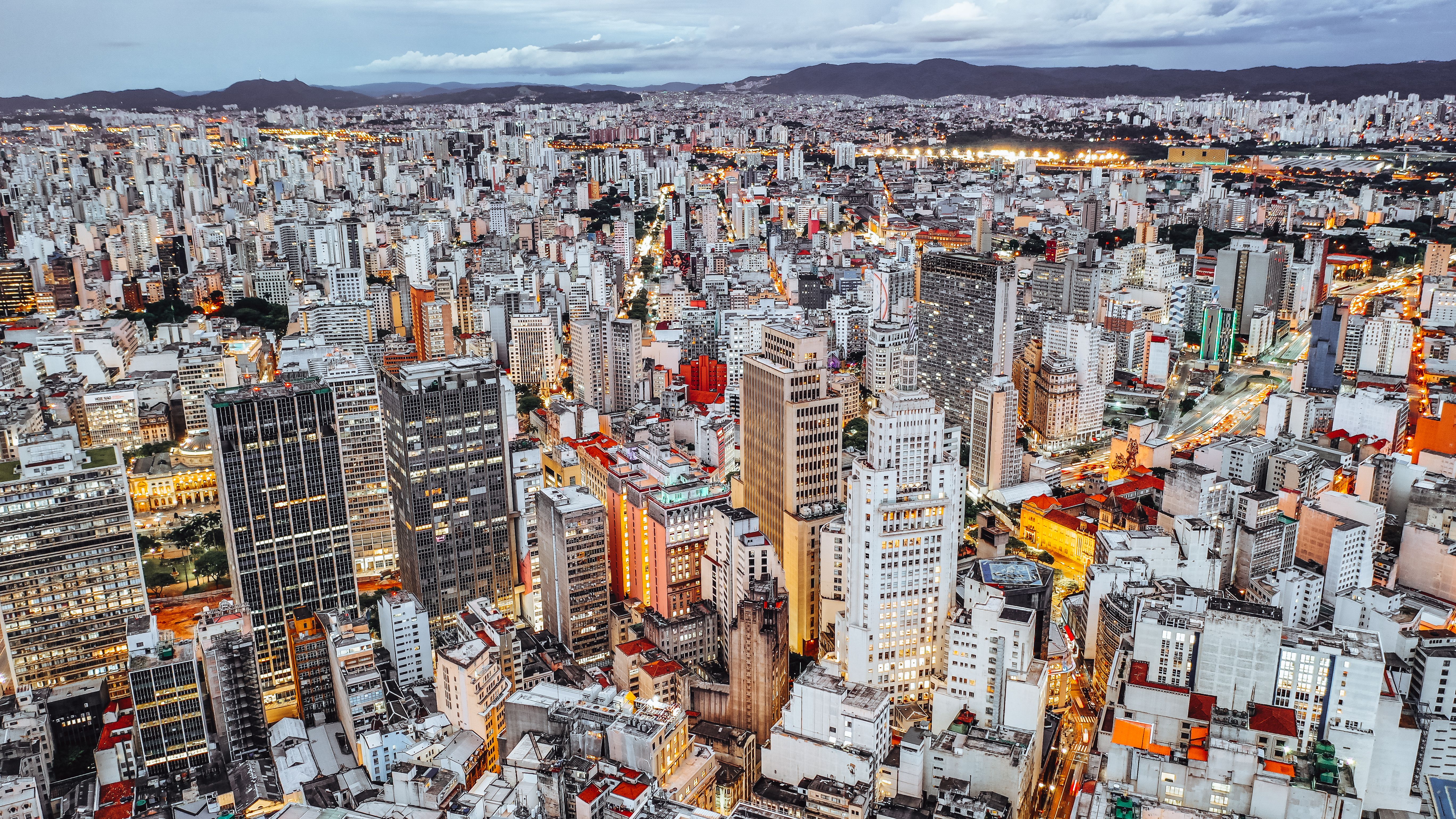 Modern megapolis with skyscrapers against high mountain · Free Stock Photo