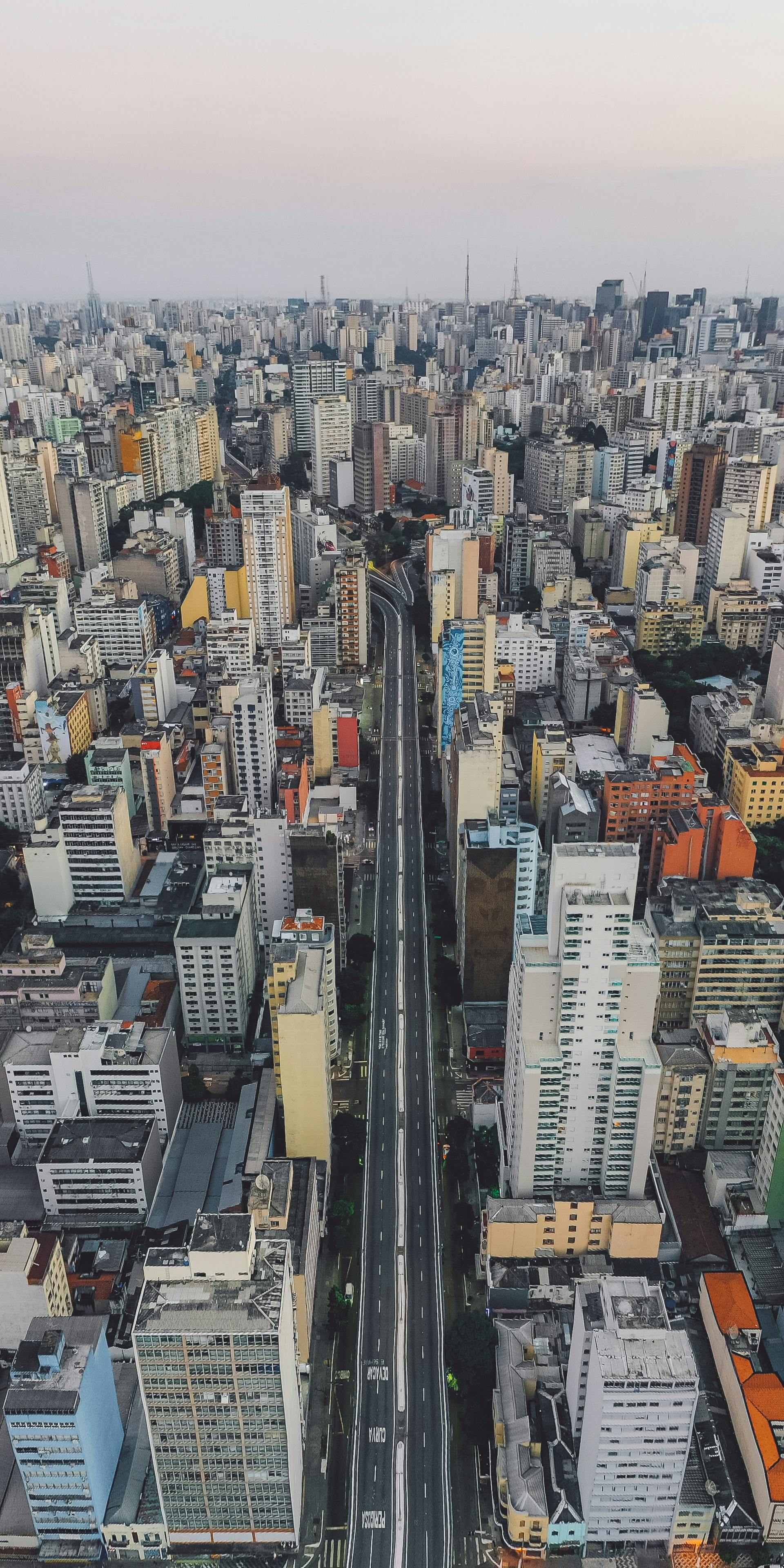 Large modern city with tall houses and long asphalt road · Free Stock Photo