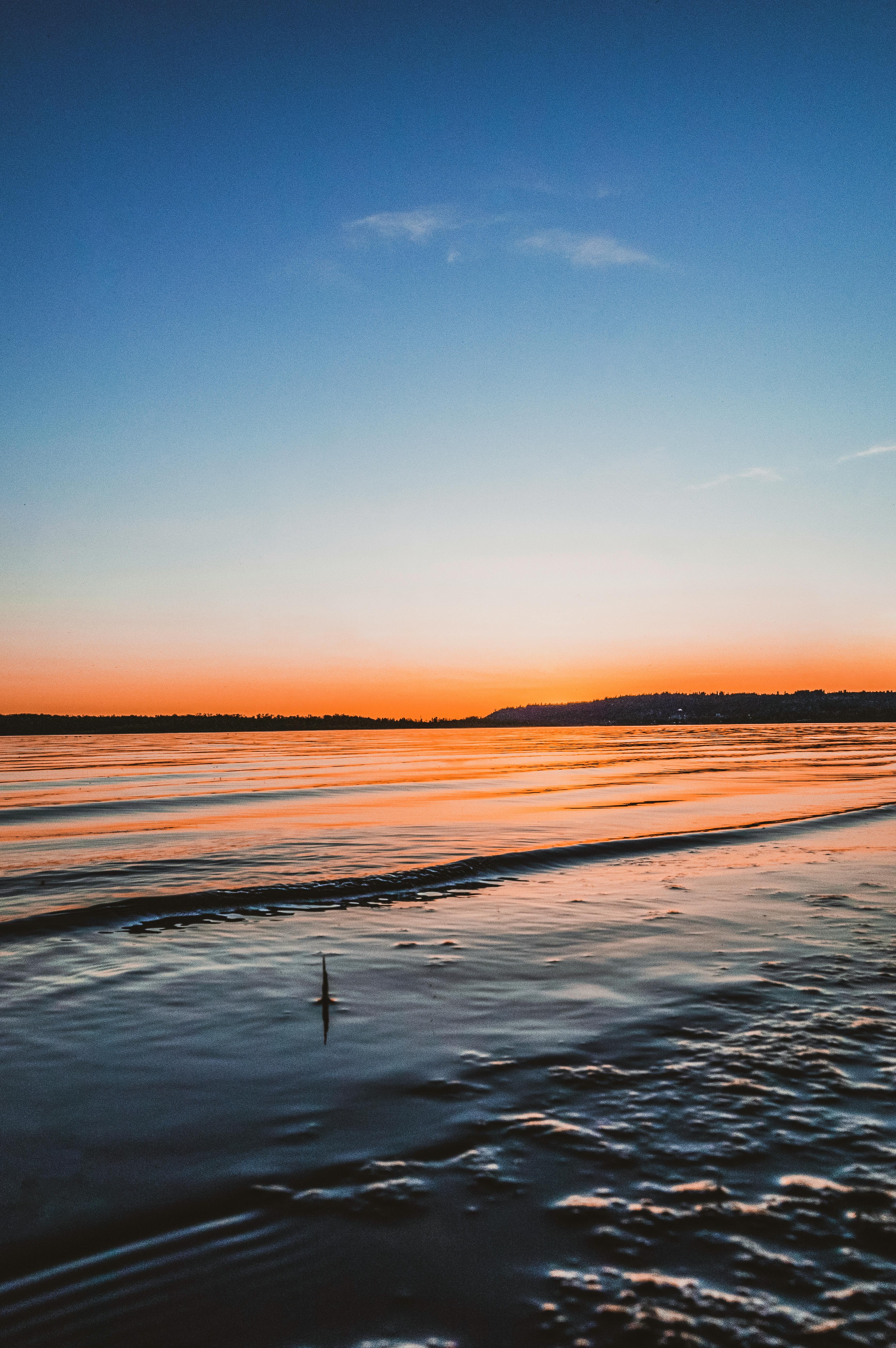 Body of Water Under Cloudy Sky During Sunset · Free Stock Photo