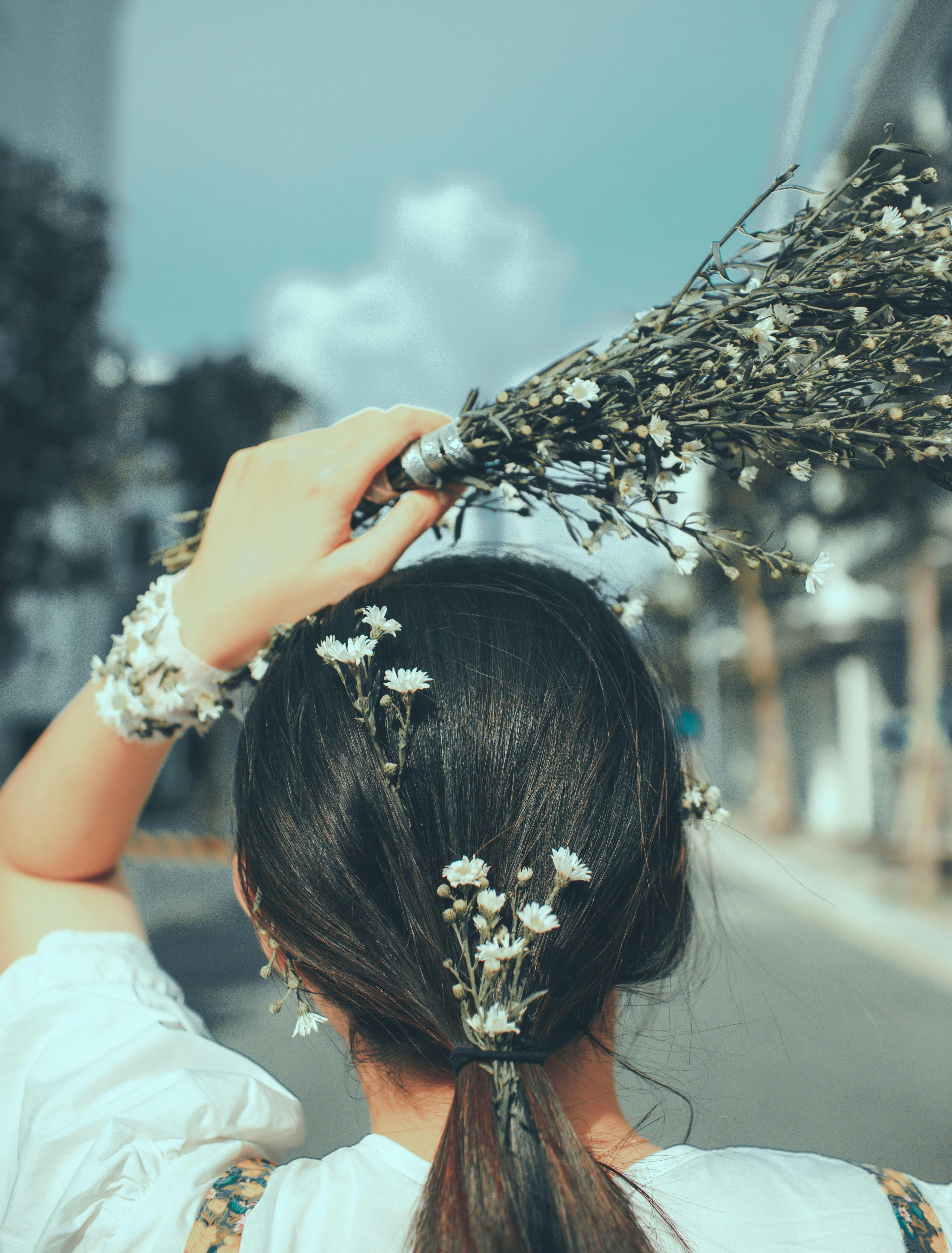 Back View of a Woman with Flowers on Her Hair · Free Stock Photo