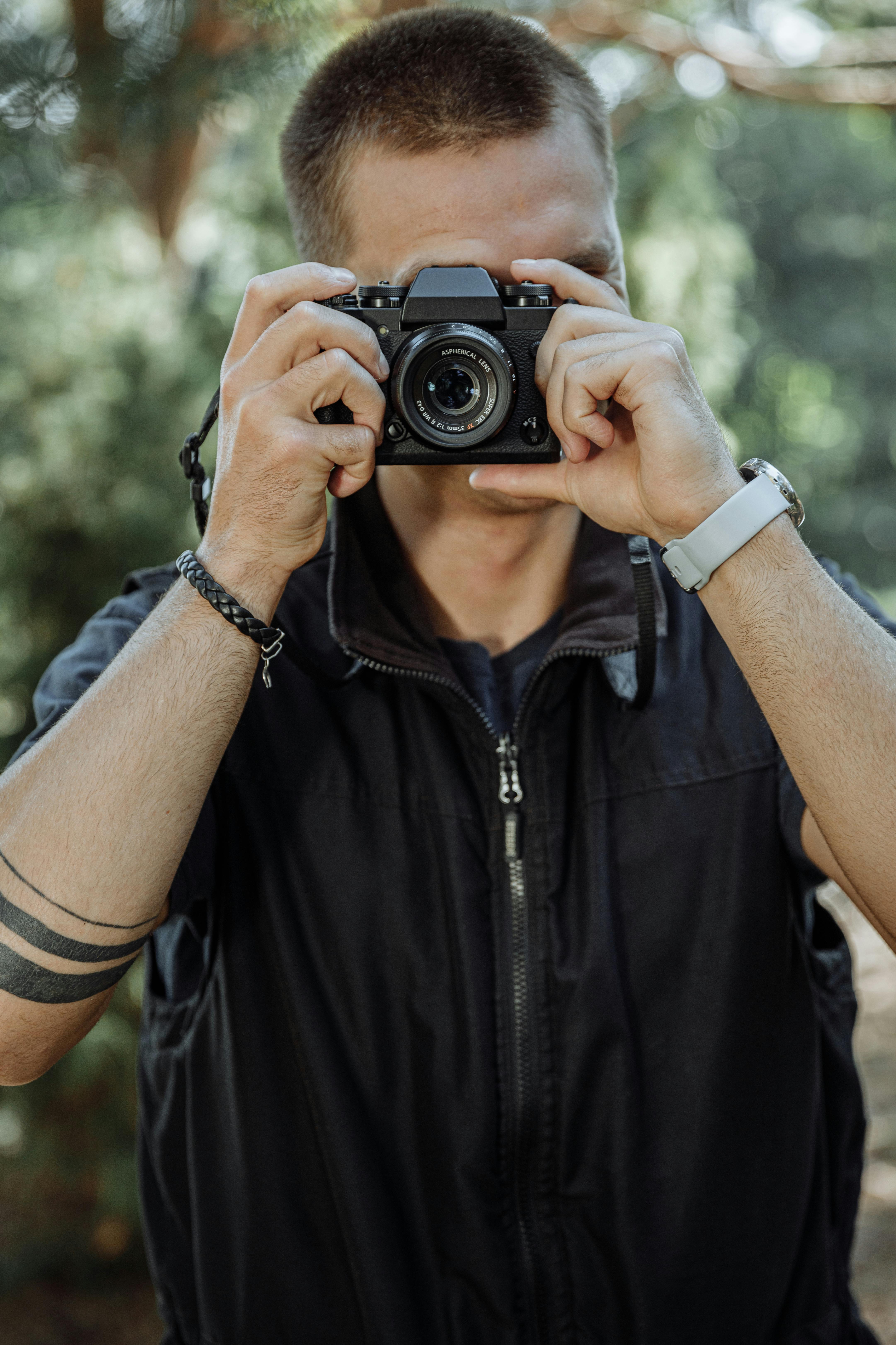 Man Holding Black Dslr Camera · Free Stock Photo