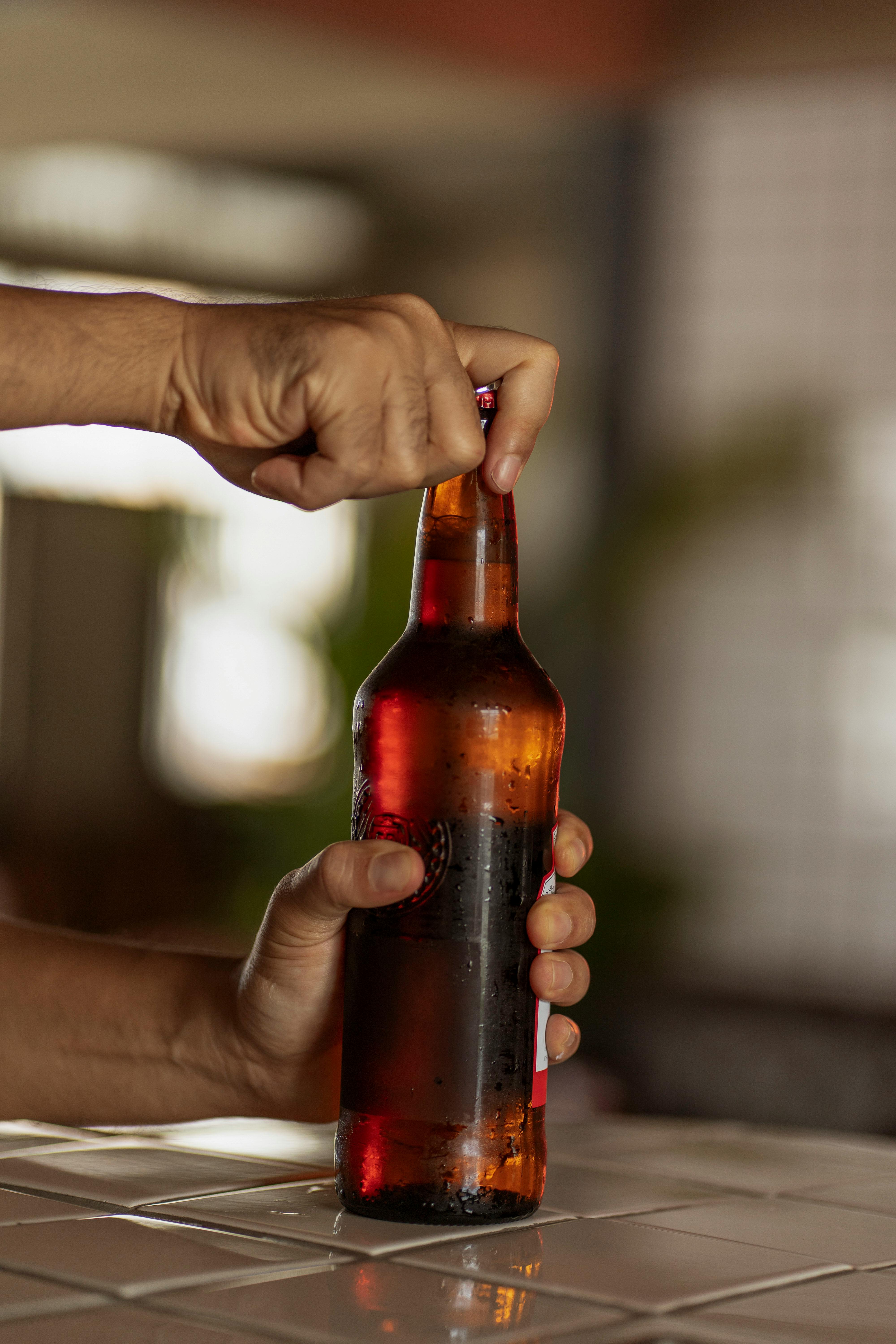 A Person Holding a Brown Glass Bottle · Free Stock Photo