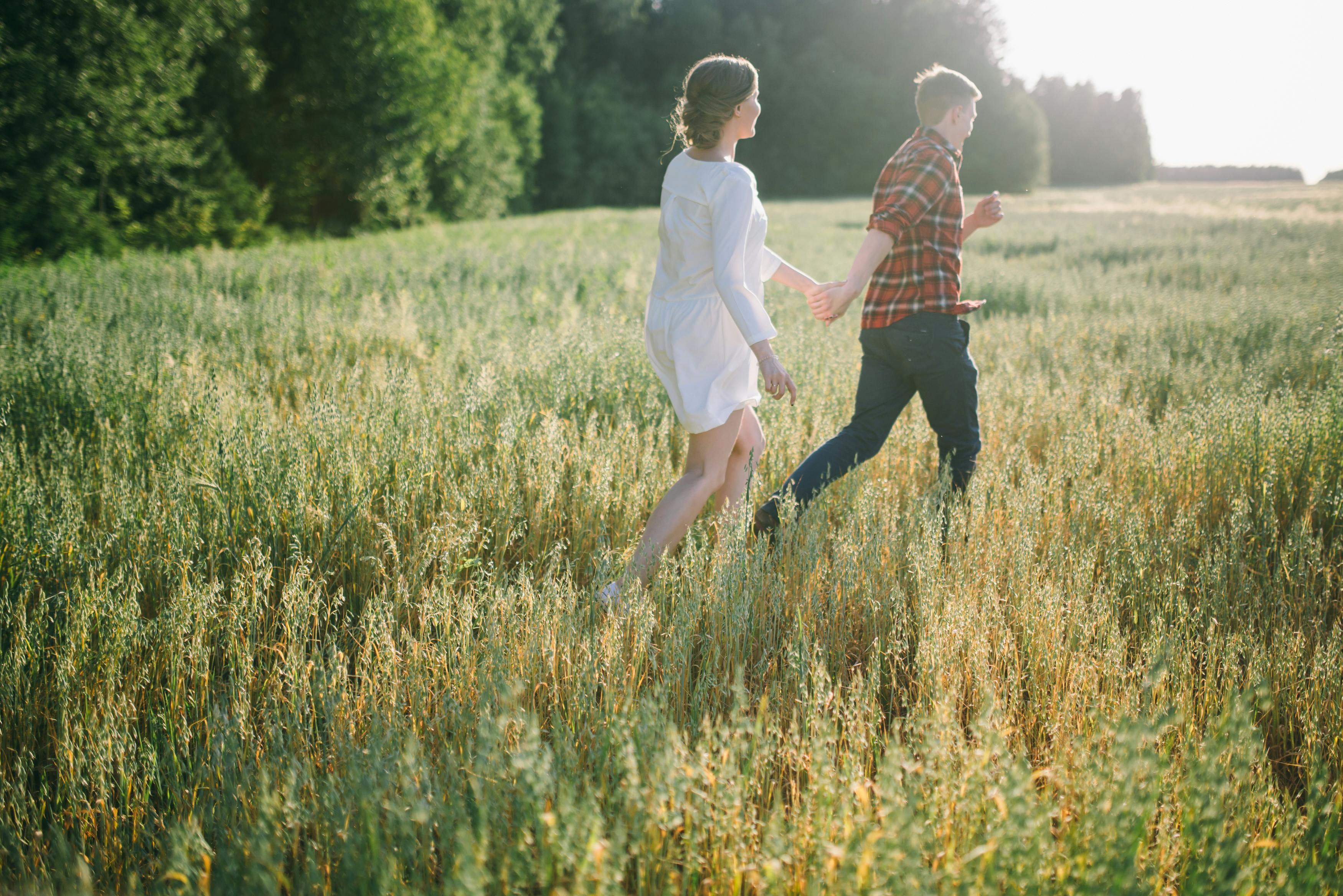 People Running Through Field Holding Hands · Free Stock Photo