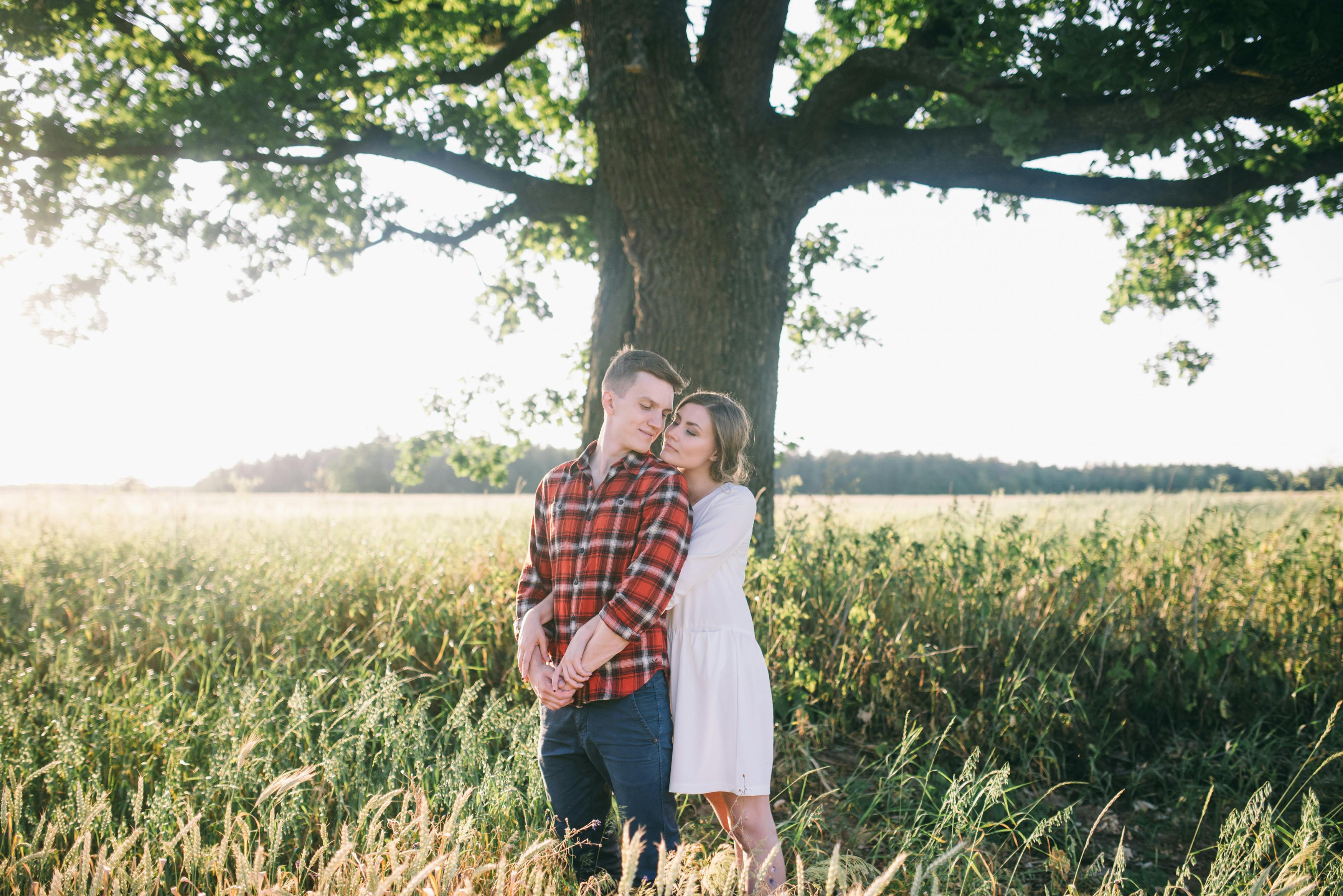 Romantic Couple Standing Beside a Tree · Free Stock Photo