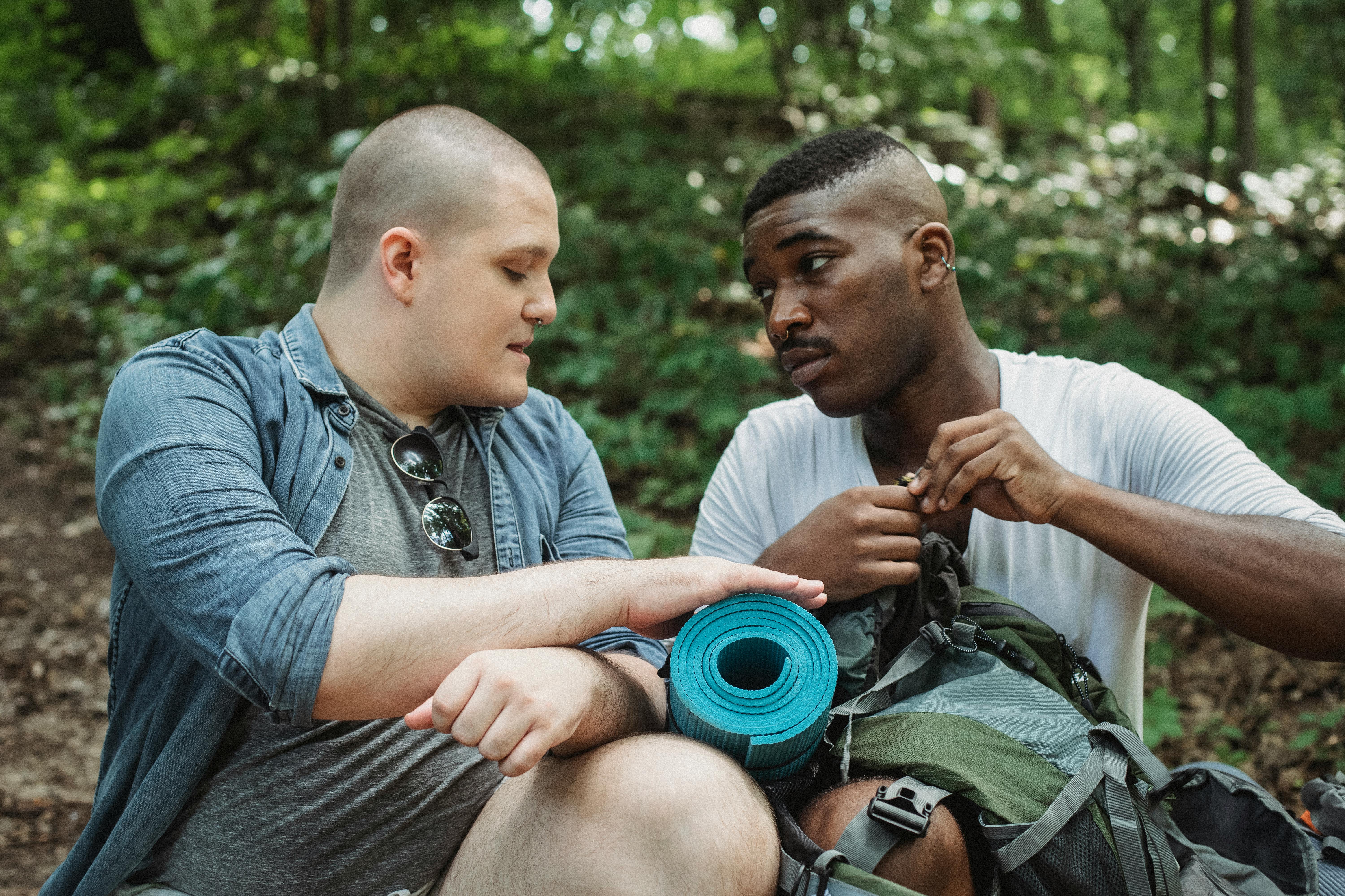 Focused hikers talking in green forest · Free Stock Photo