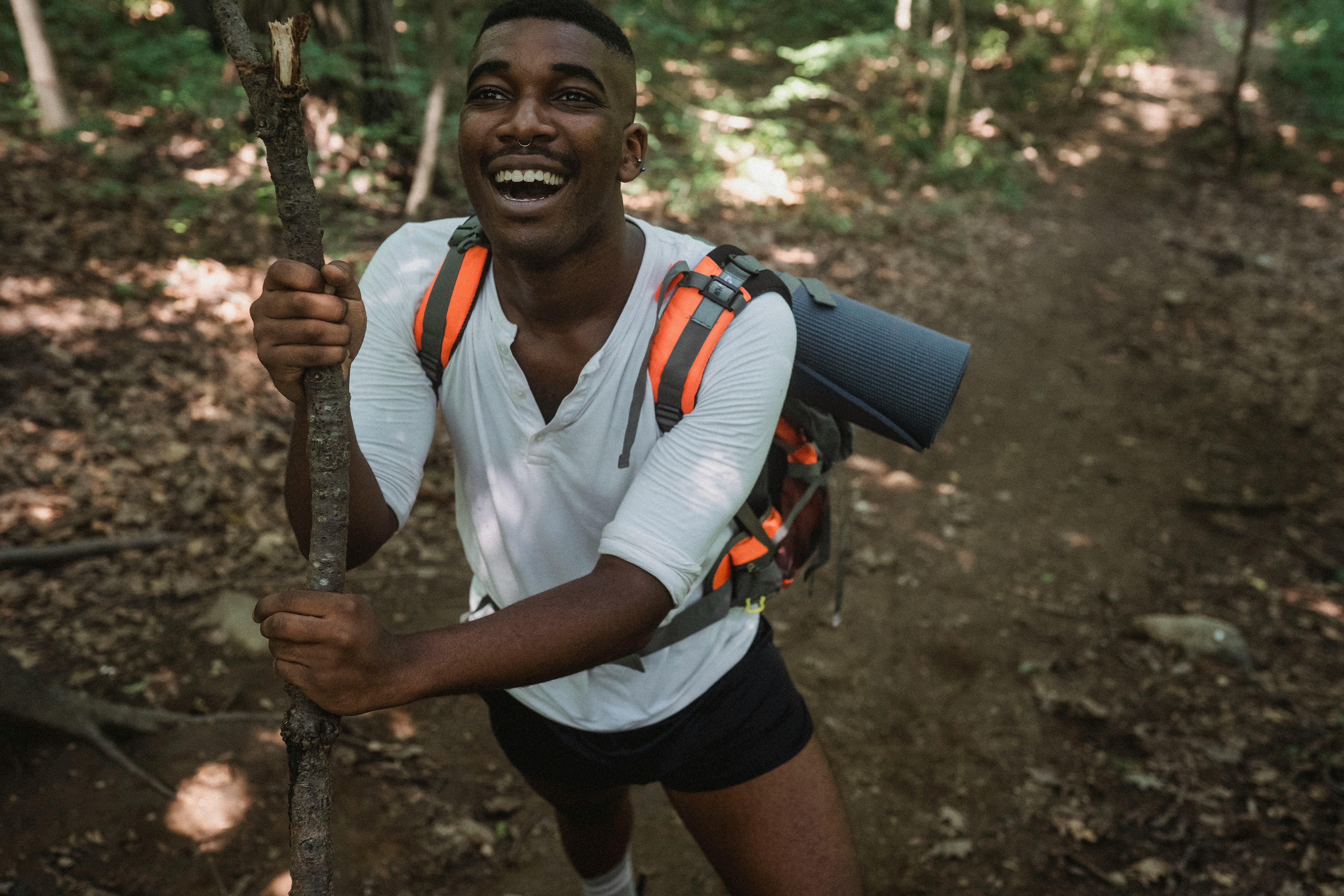 Crop happy black man with backpack standing in forest · Free Stock Photo