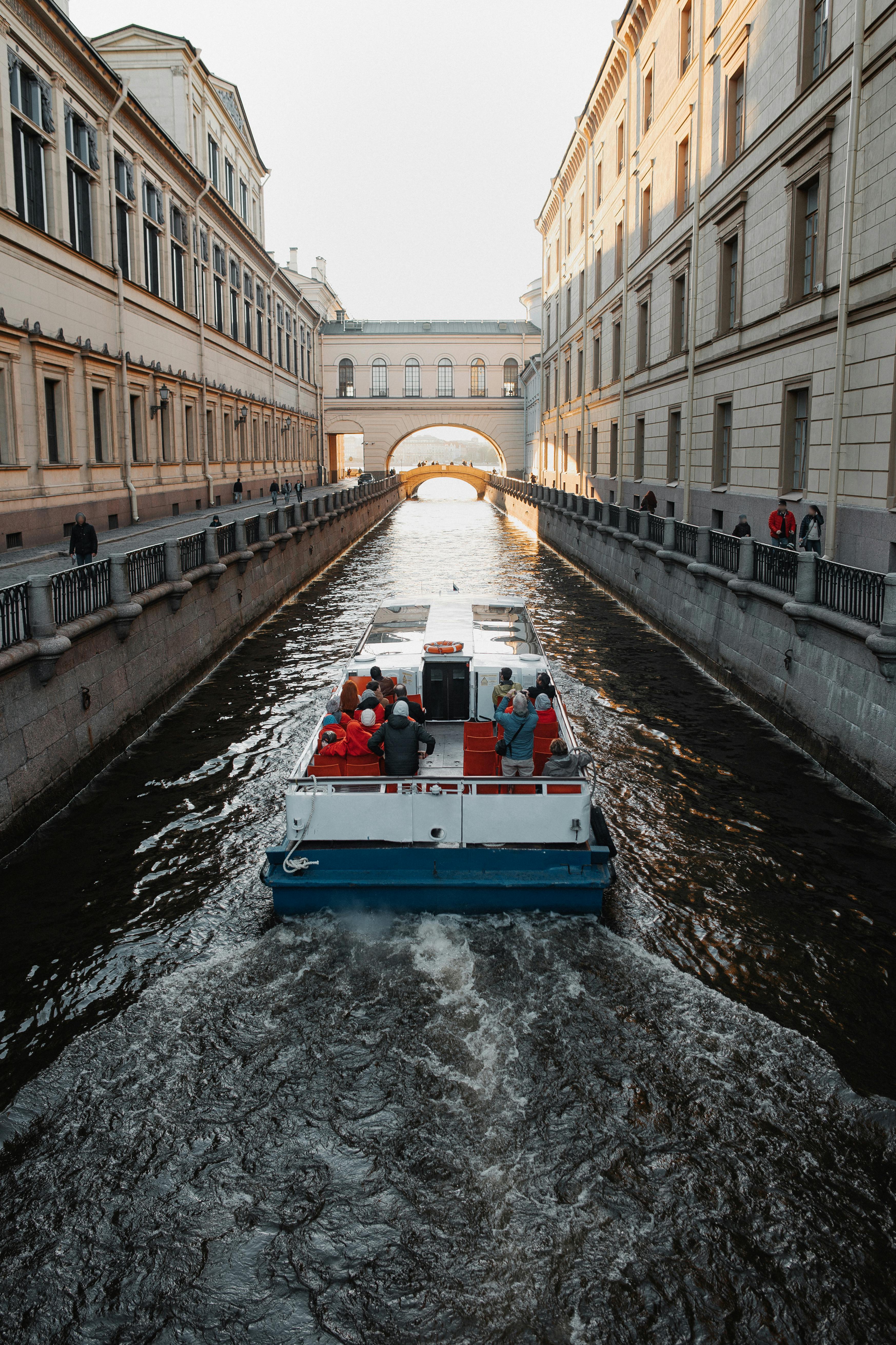 People on Motorboat on Canal in Town · Free Stock Photo