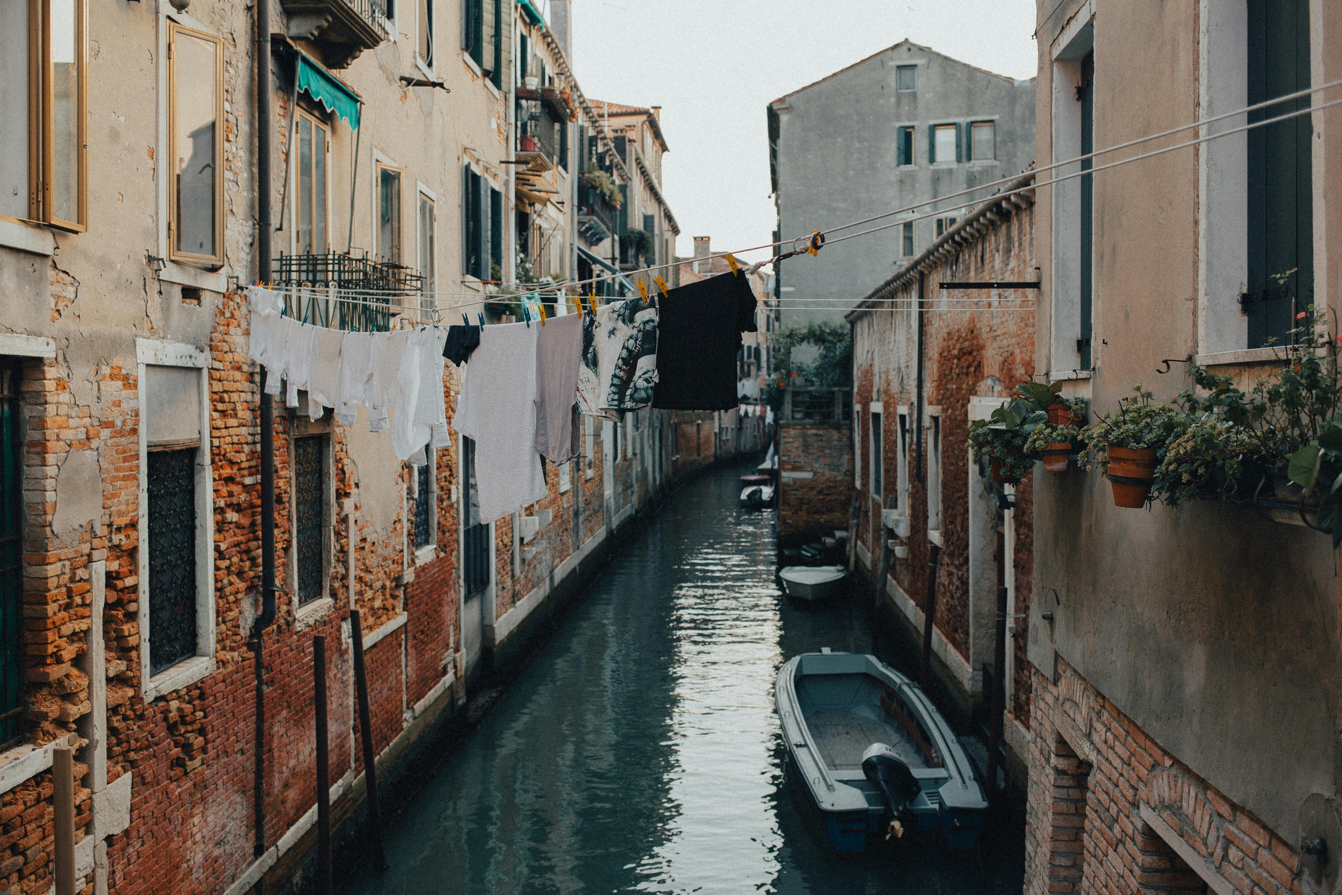Boat on River Between Buildings · Free Stock Photo