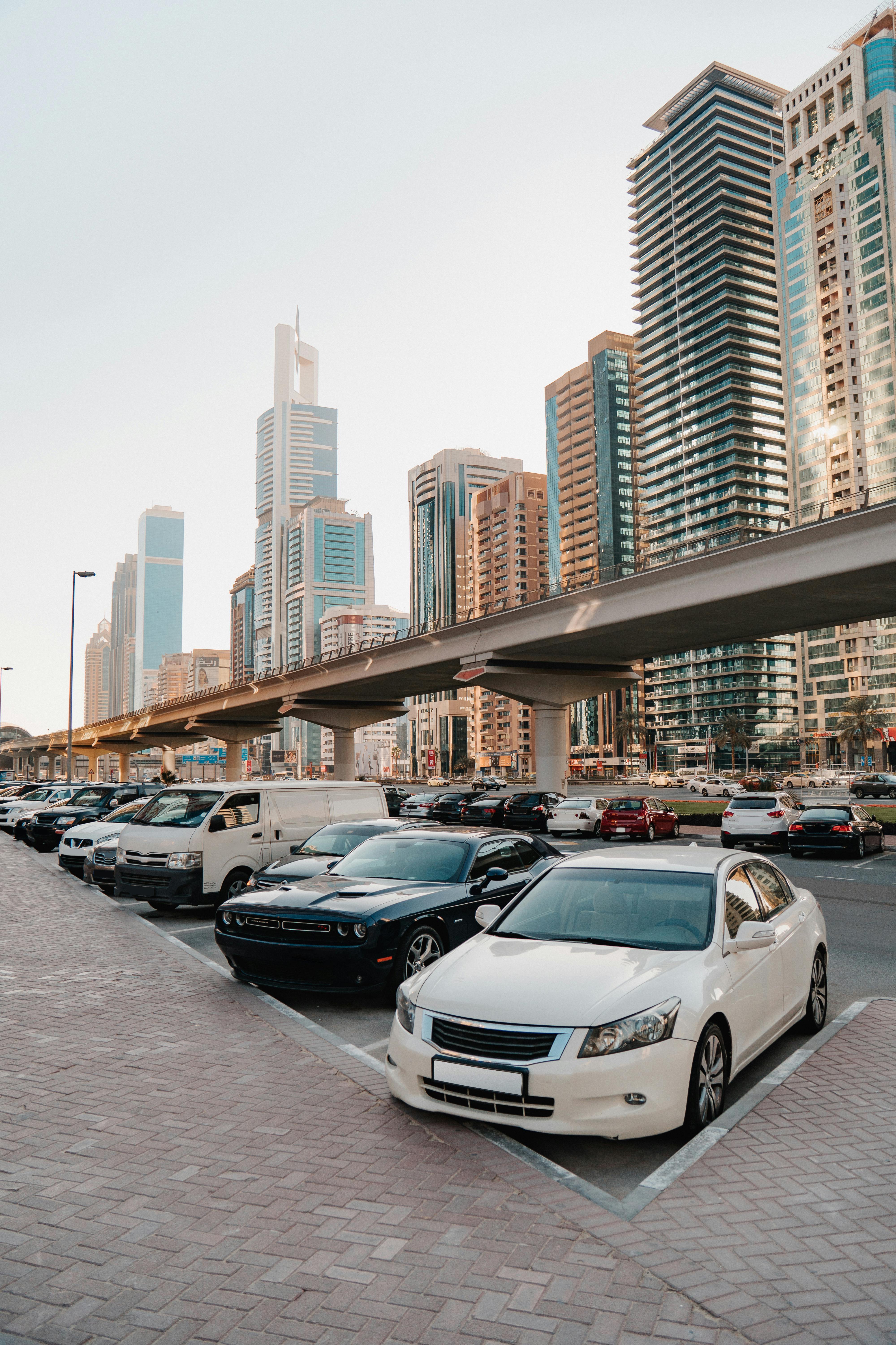 Cars Parked on Parking Lot Near High Rise Buildings · Free Stock Photo