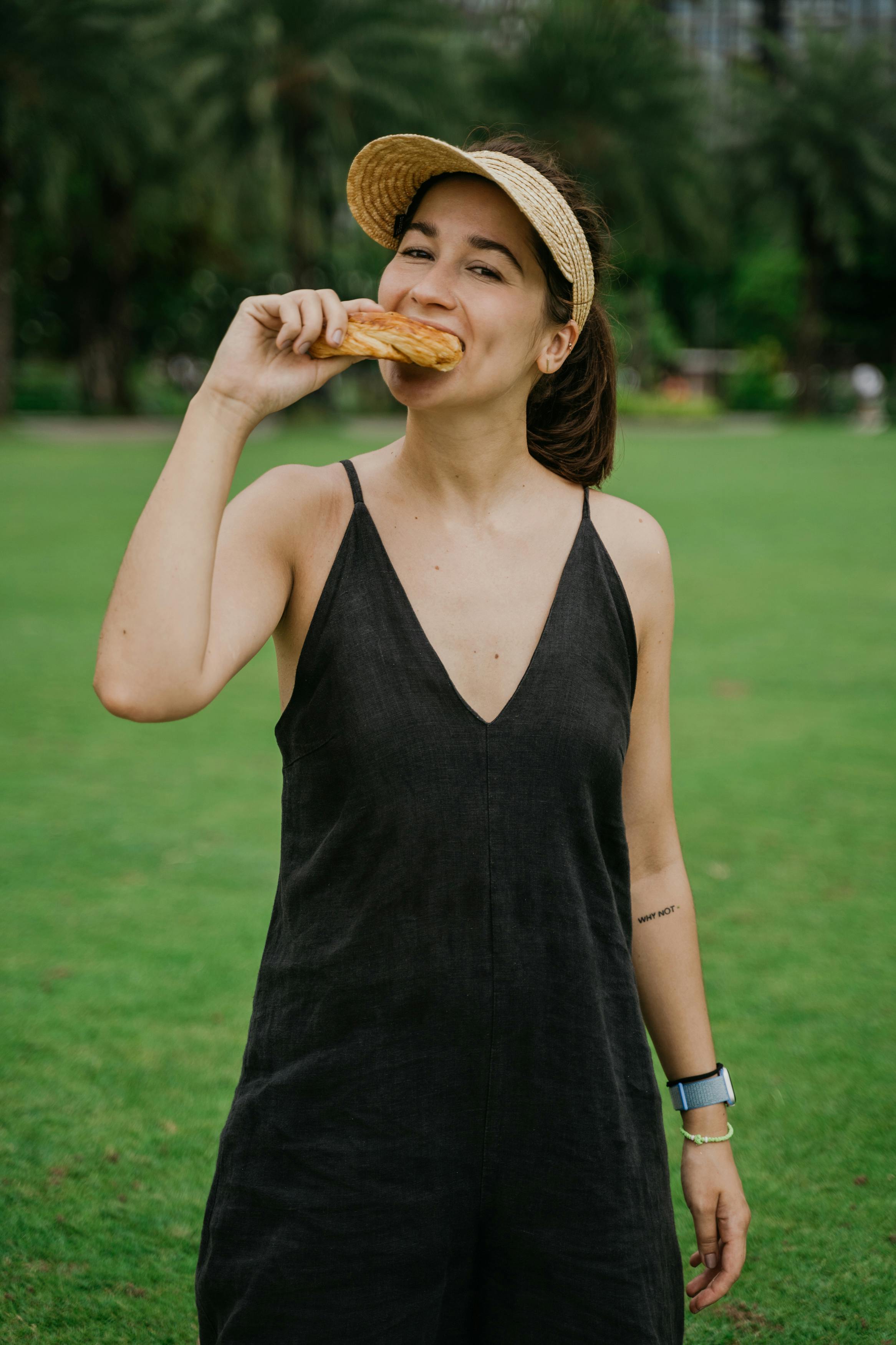 Woman Eating Bun in Park · Free Stock Photo