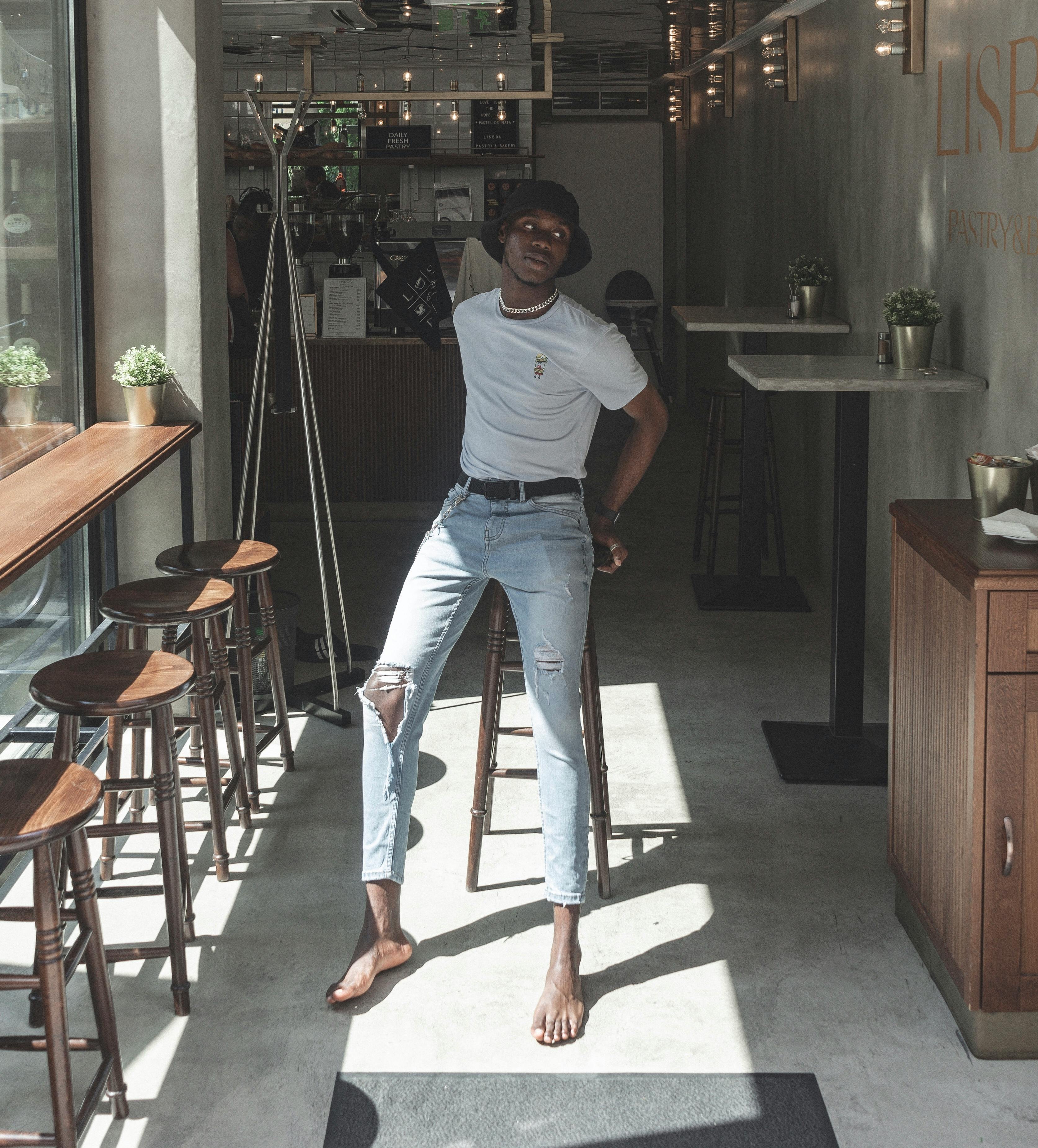 Man Sitting on a Bar Stool in a Street Full of Graffiti · Free Stock Photo