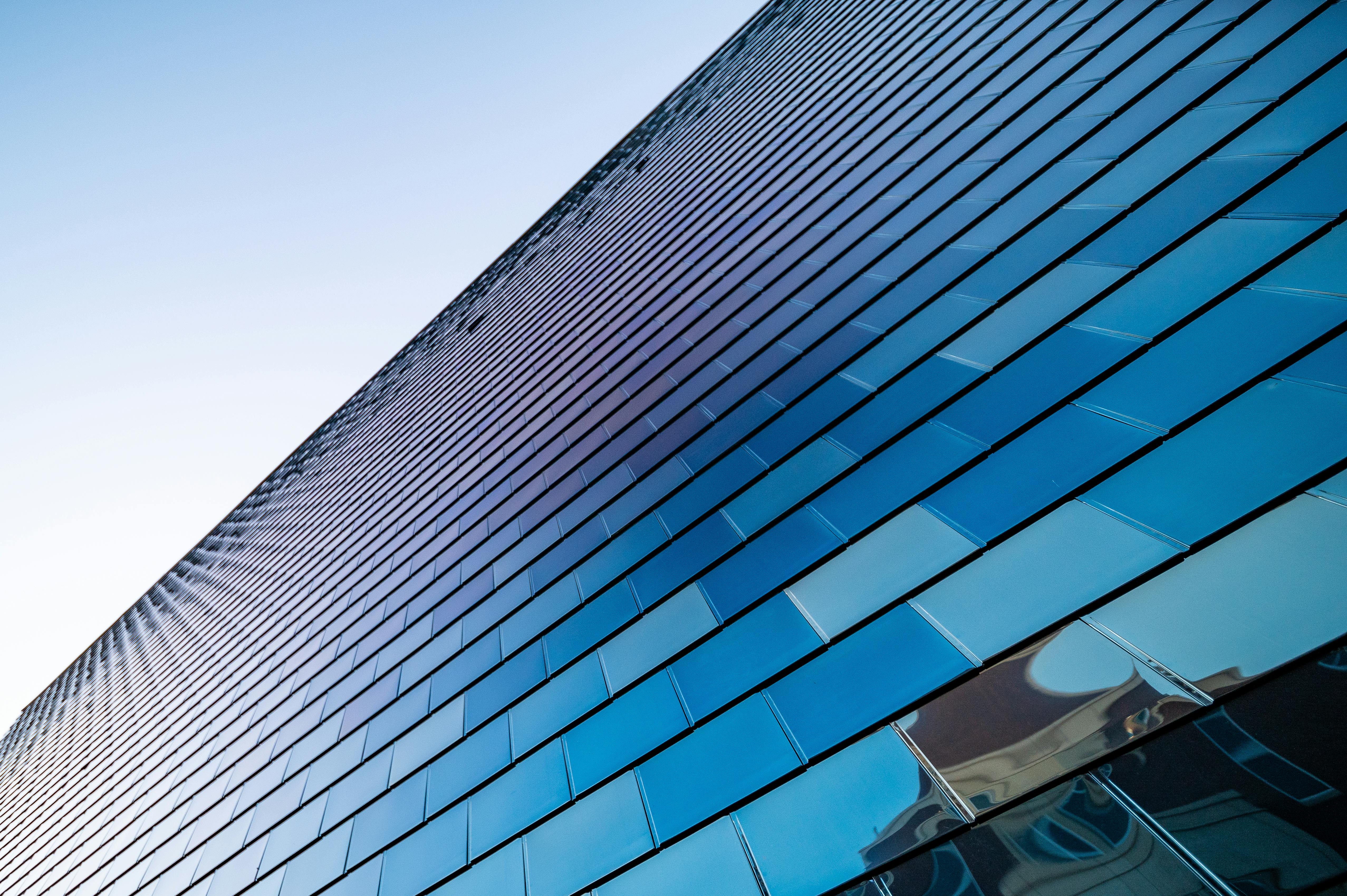 Blue tiled building wall reflecting clear sky · Free Stock Photo