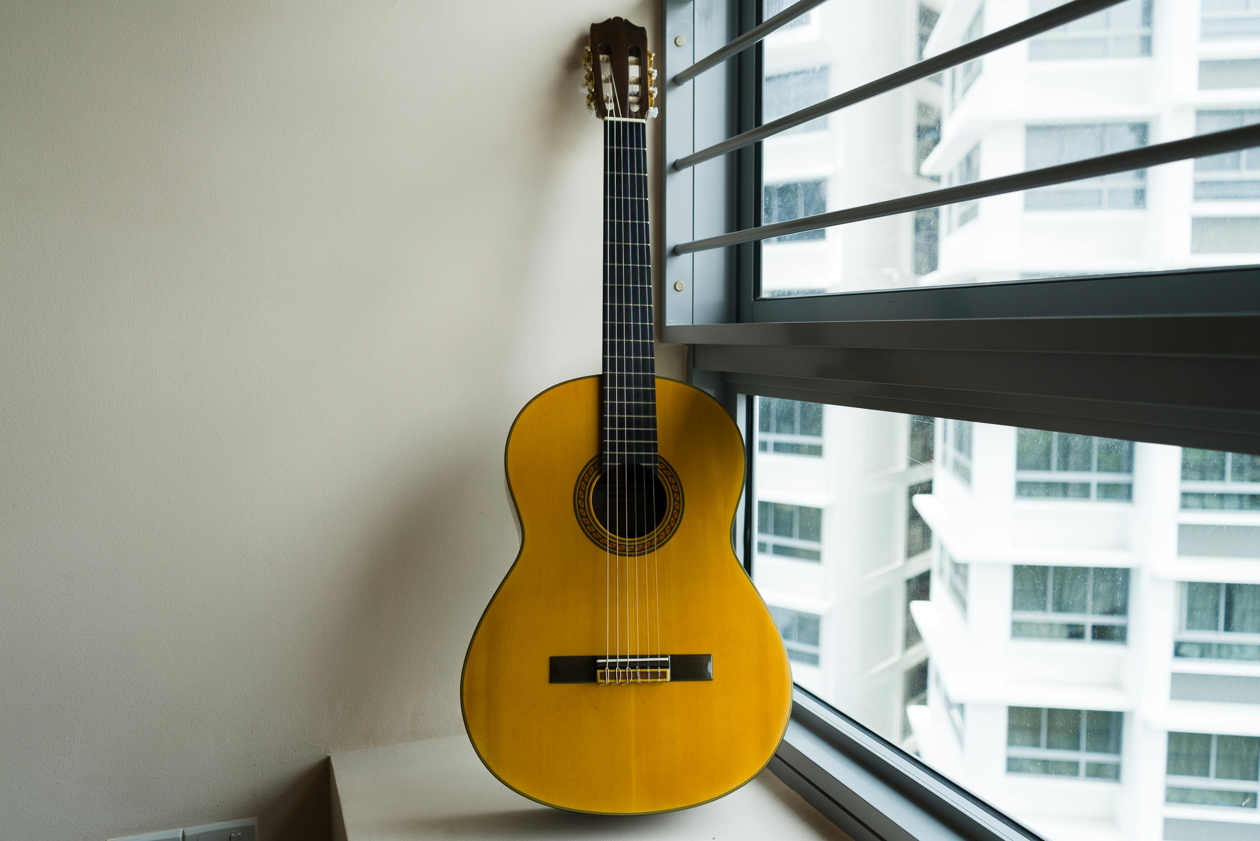 Acoustic Guitar on White Wall Beside the Window · Free Stock Photo