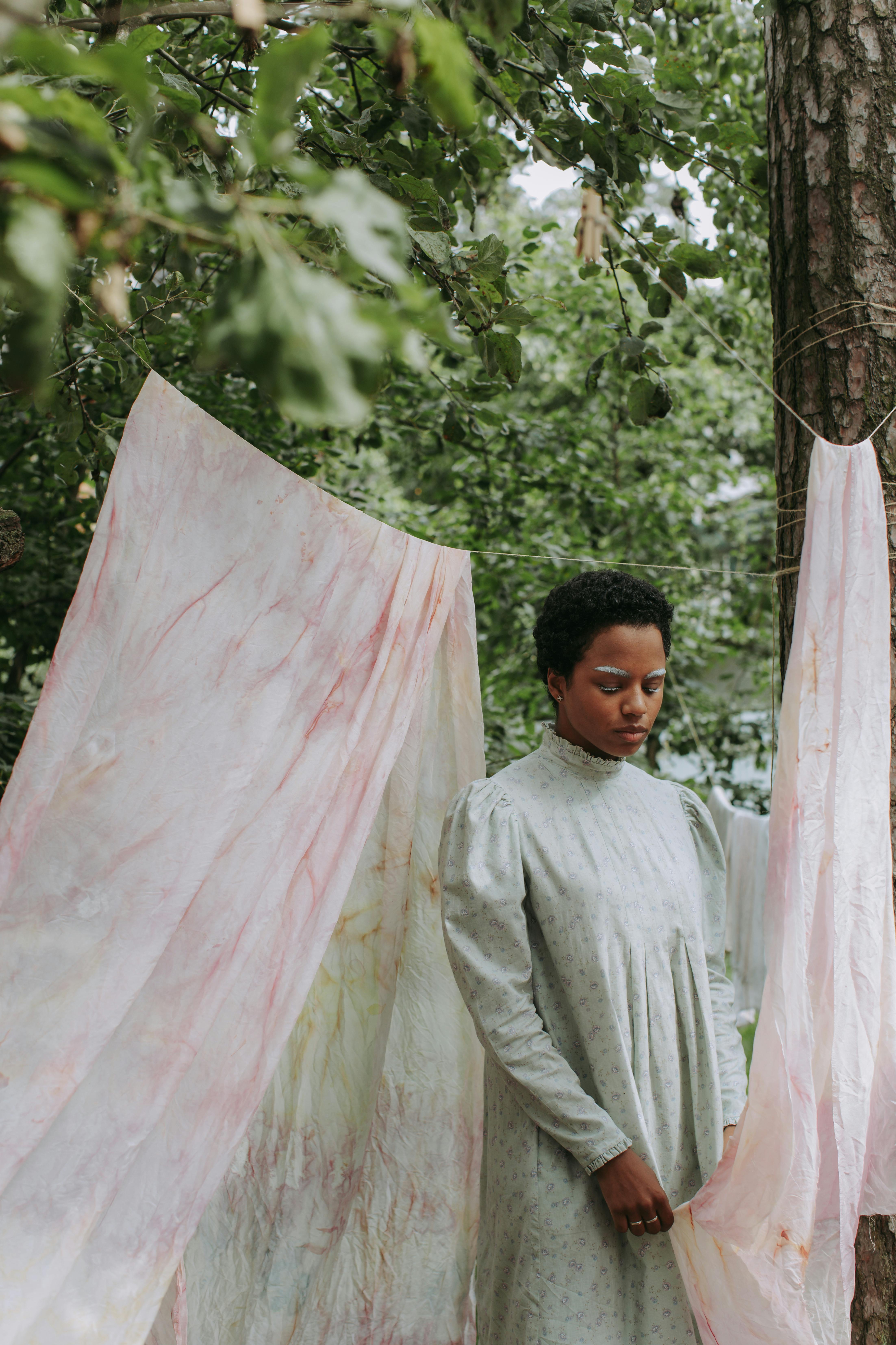 A Woman Hanging Sheets on Clothes Line · Free Stock Photo