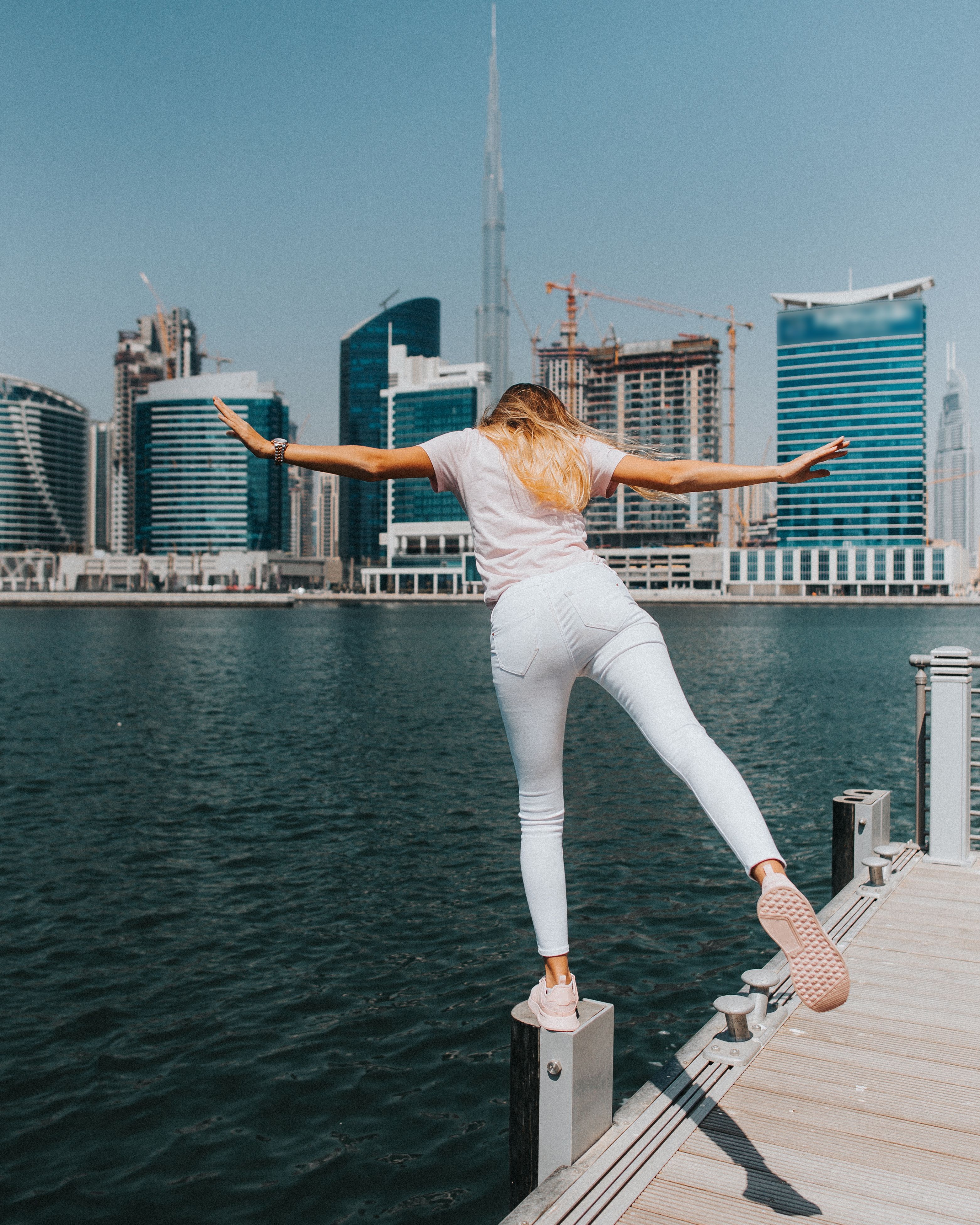 Back View of a Woman Balancing on the Side of the Dock · Free Stock Photo
