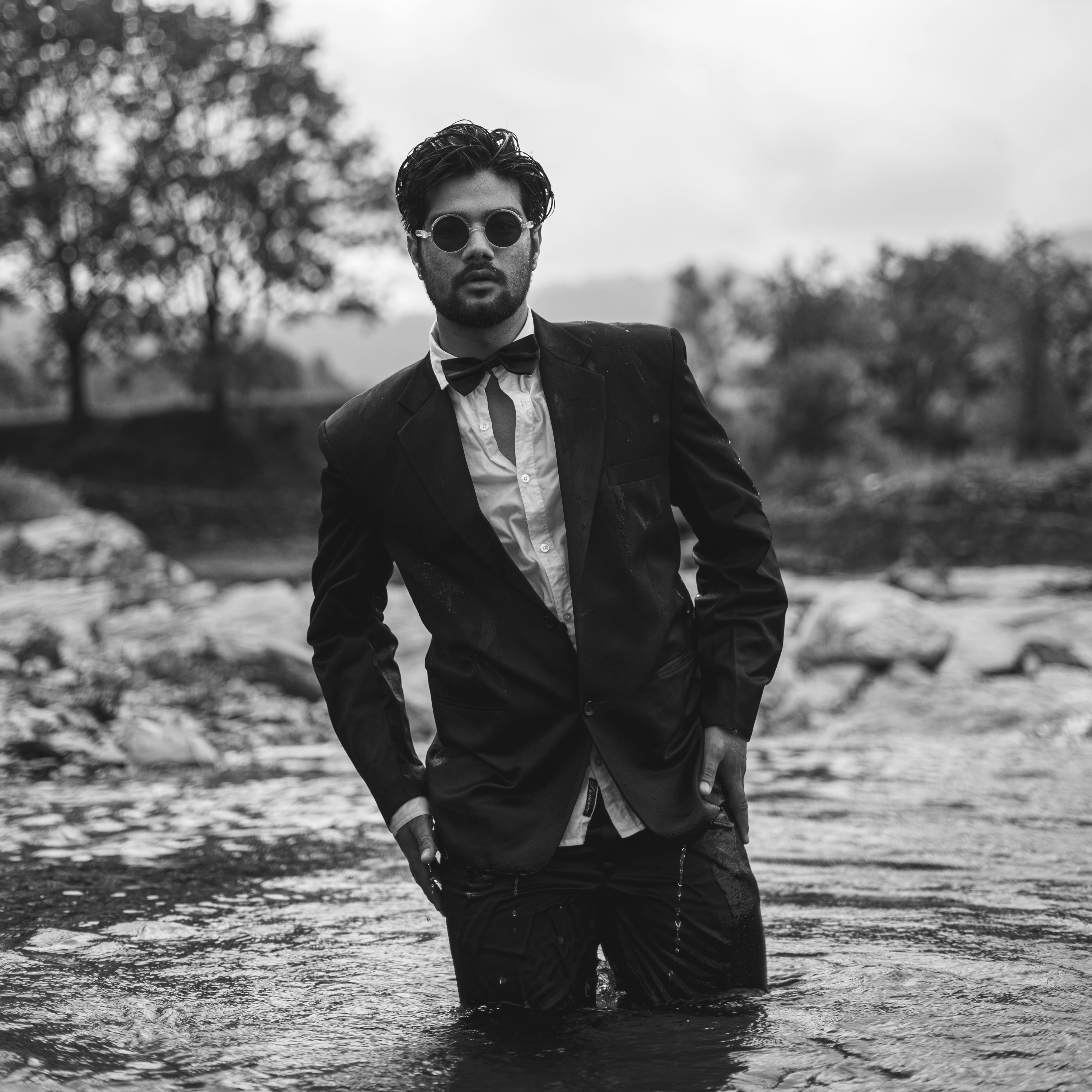 Grayscale Photo of a Man in Suit Standing in Water · Free Stock Photo