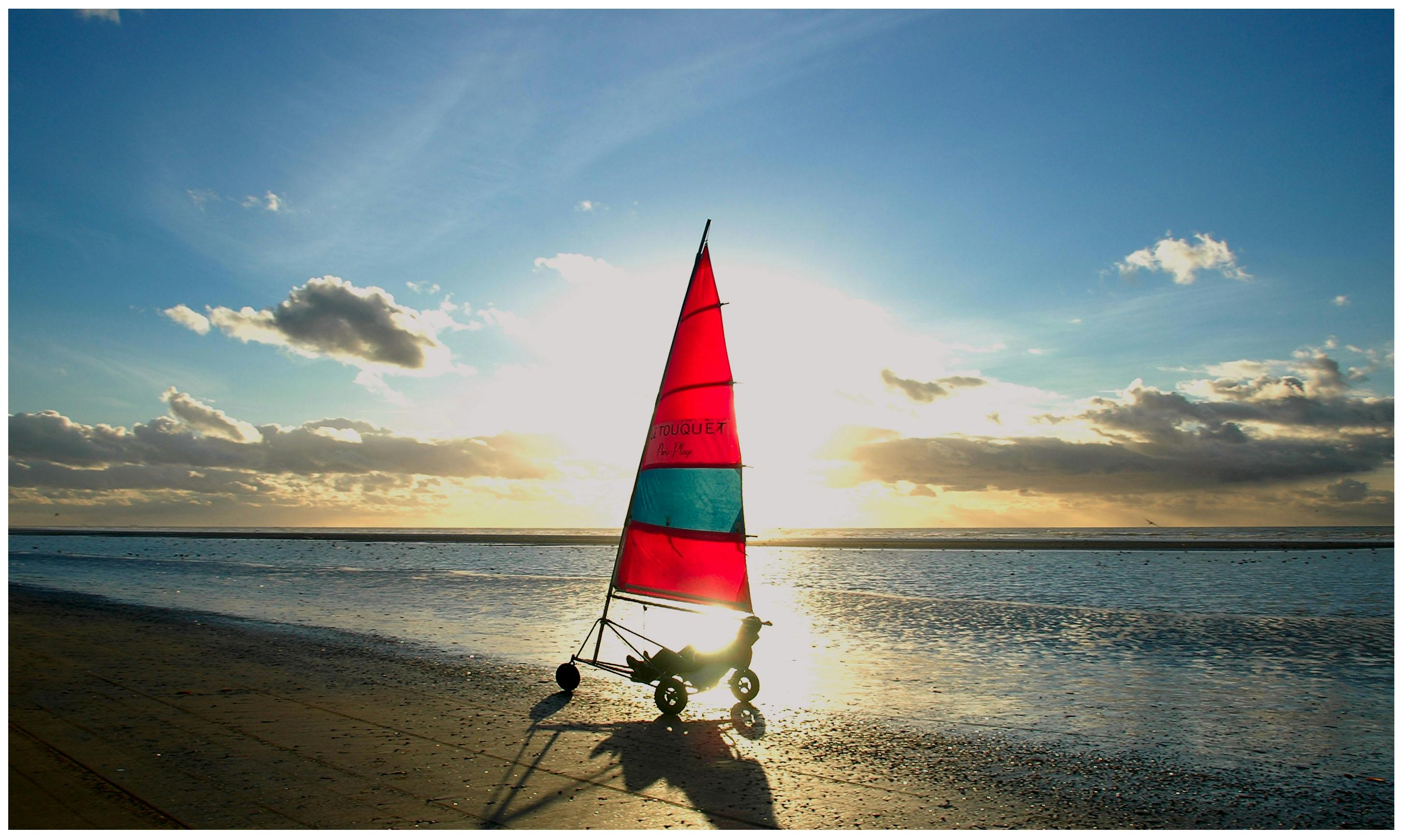 Man Riding Sailboat on Beach Sand · Free Stock Photo