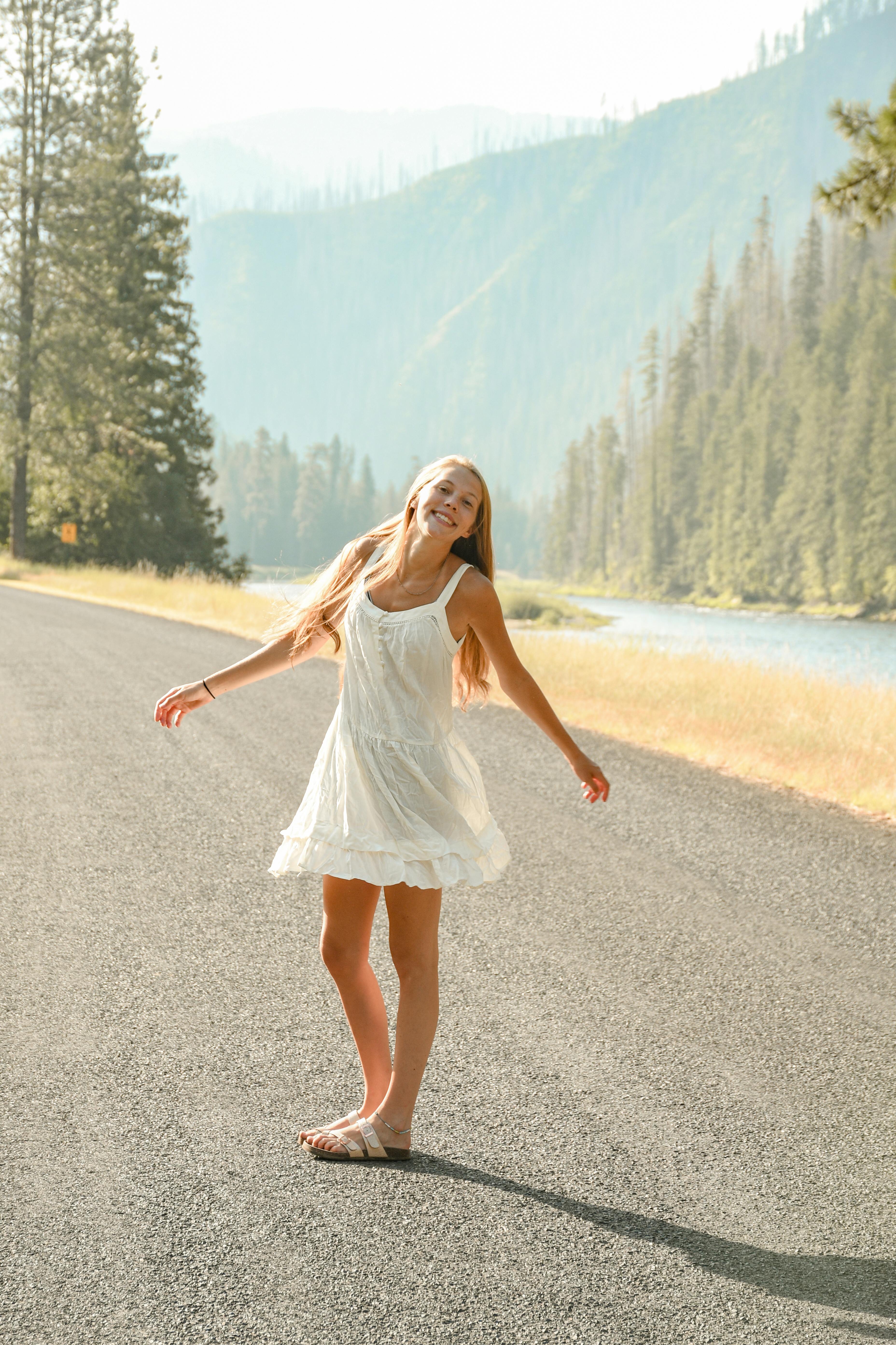 Positive female teen in trendy sundress on road · Free Stock Photo