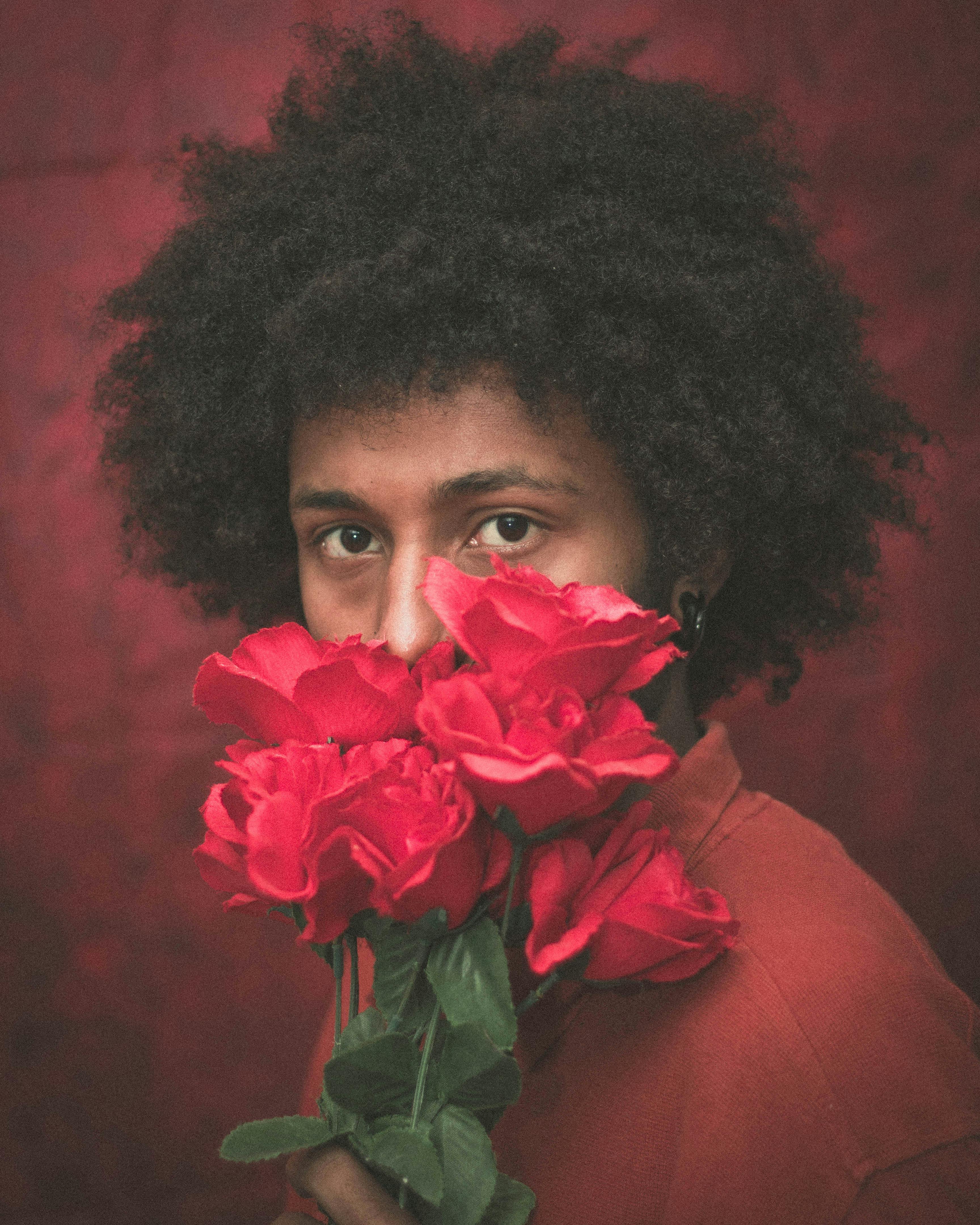 Close-Up Photo of a Man with Afro Hair Holding a Bunch of Red Roses ...