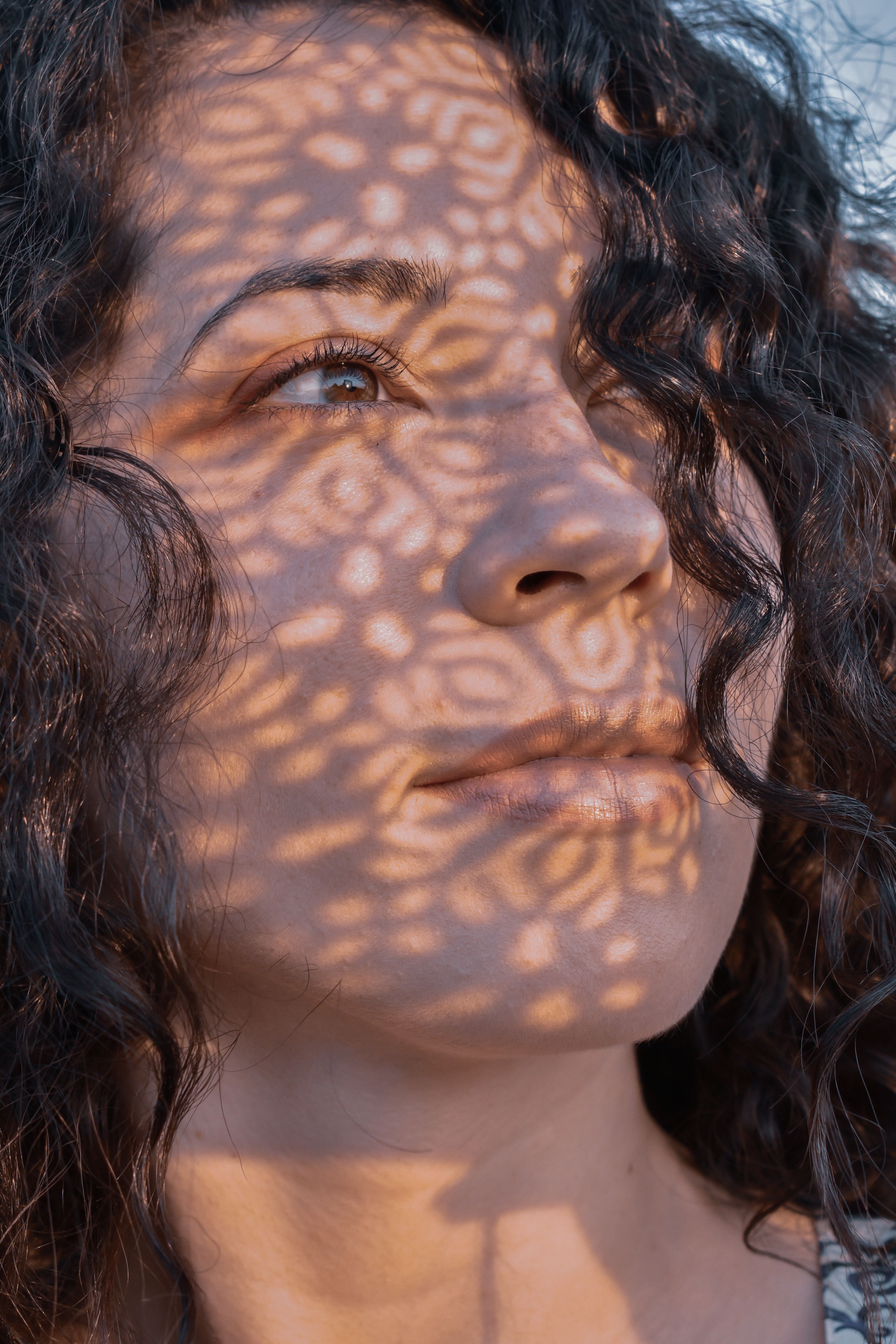 Woman with curly hair and shadows on face · Free Stock Photo