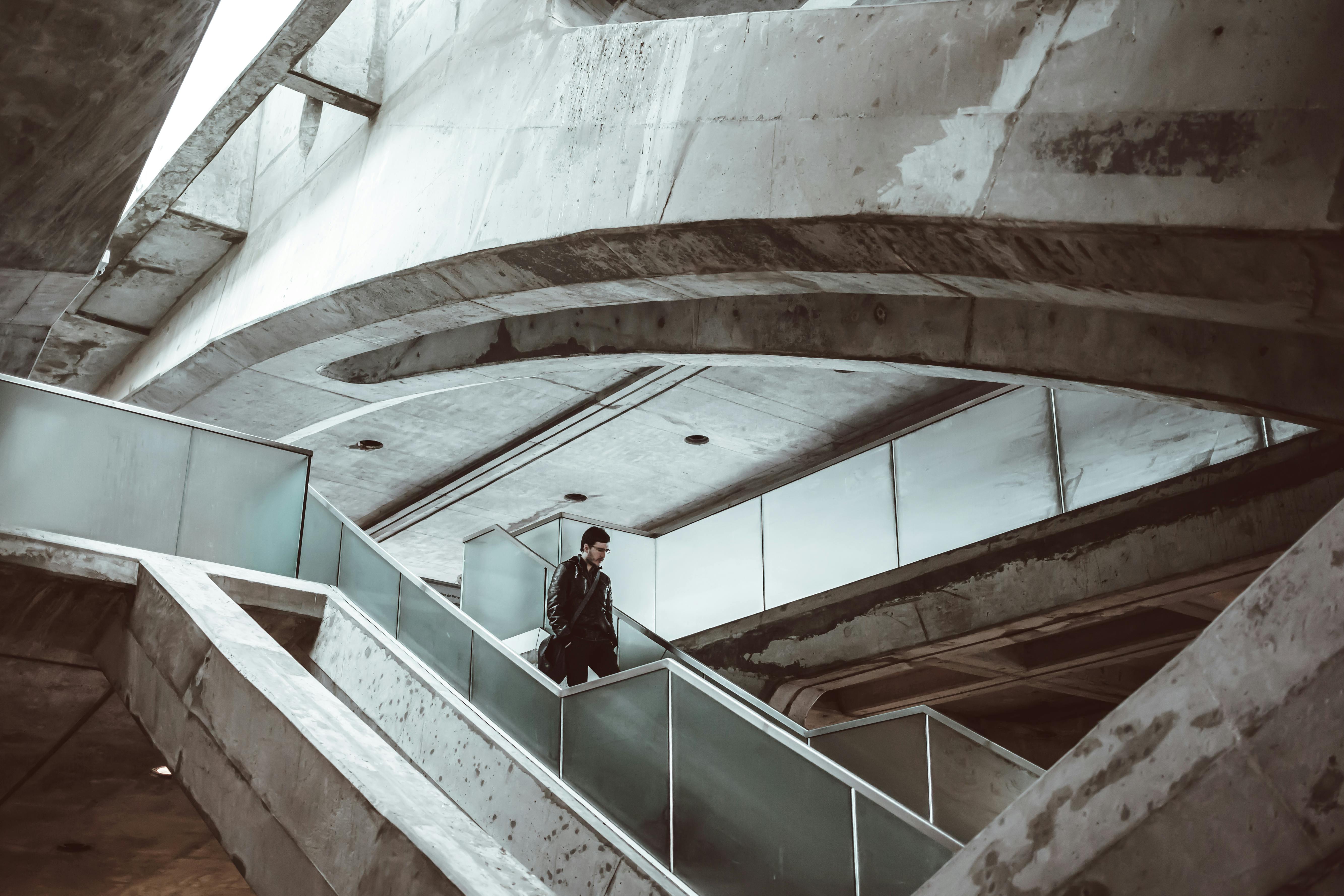 Man on stairs in concrete futuristic building · Free Stock Photo