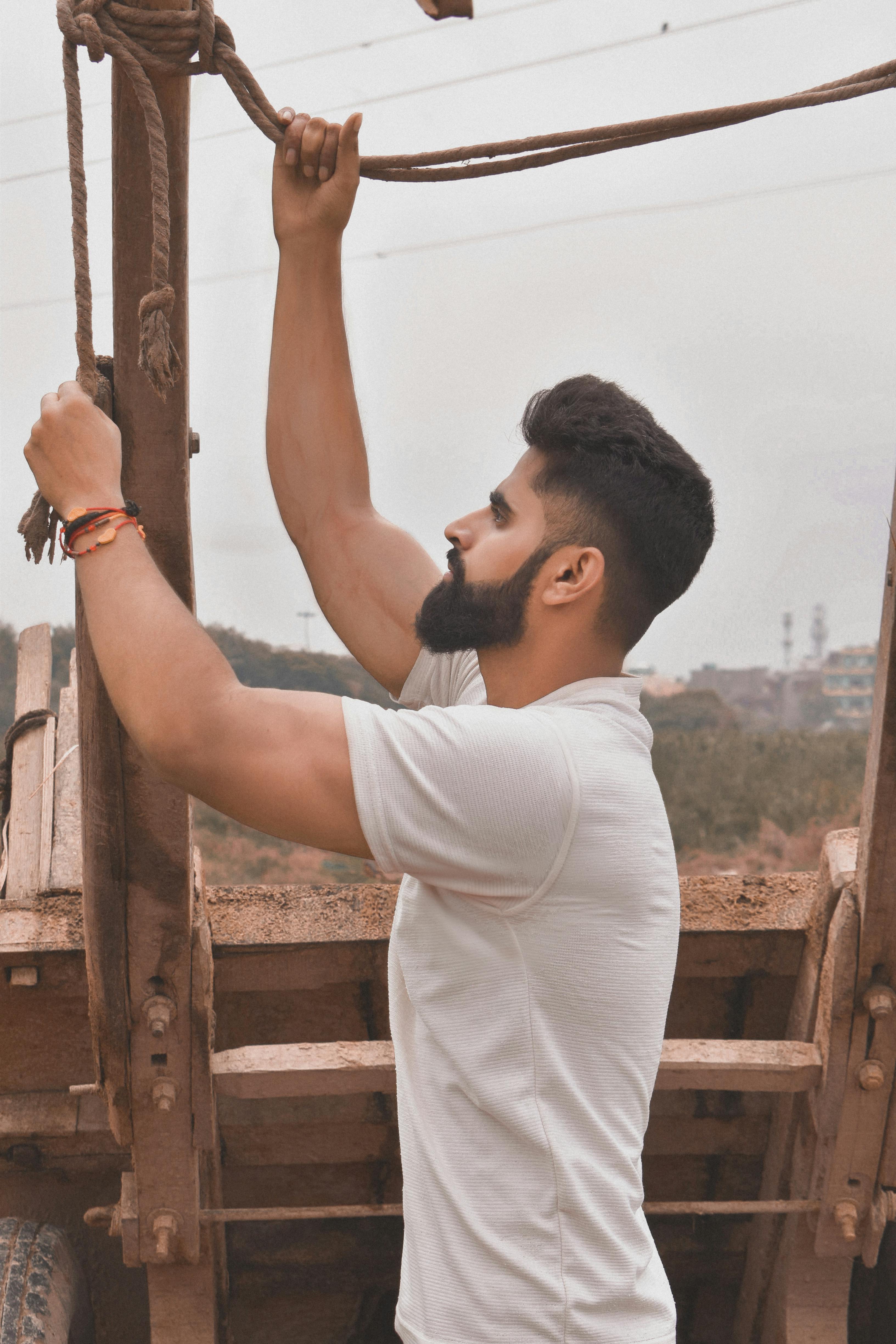 A Bearded Man in White Shirt Tying the Rope · Free Stock Photo