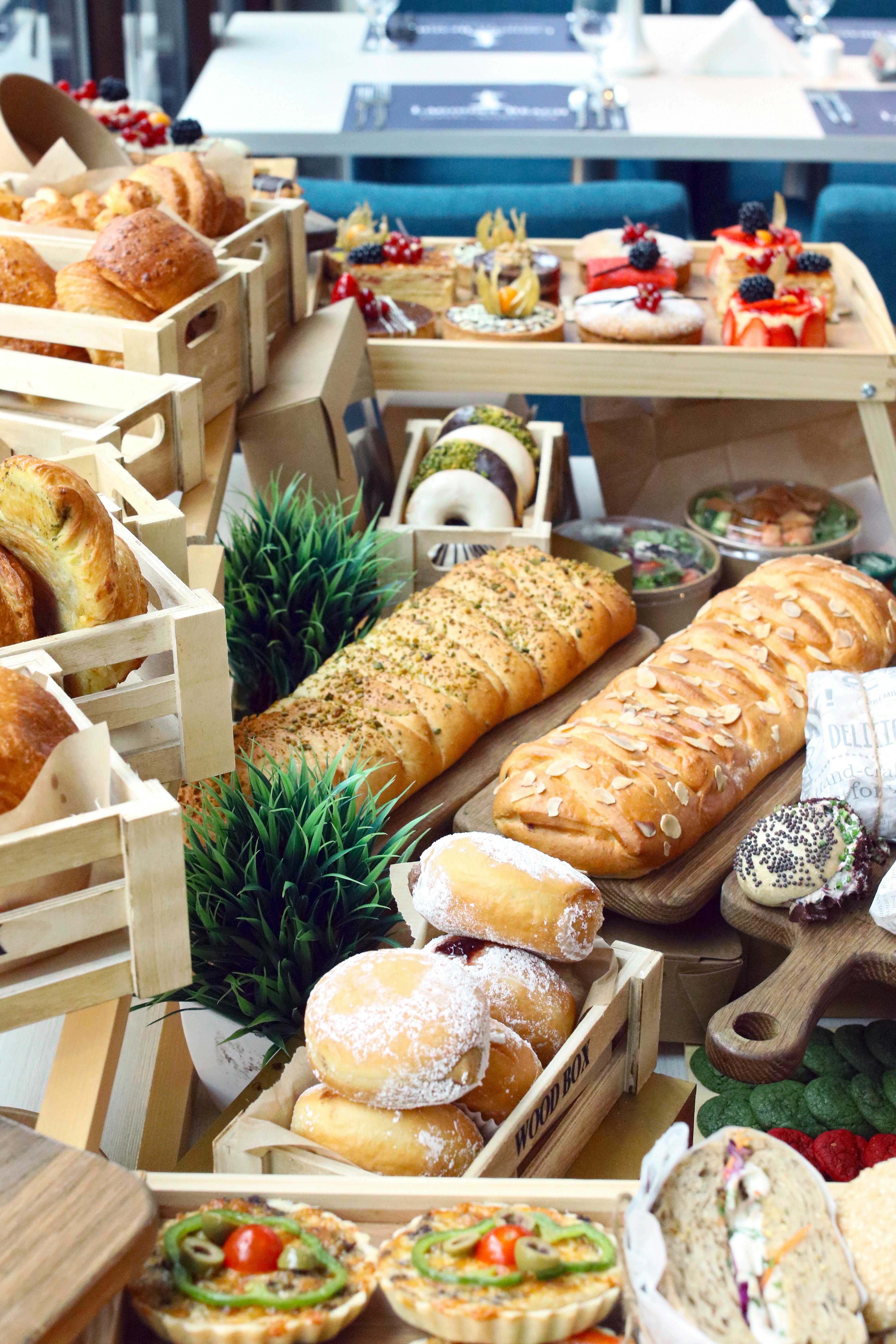 Baked Goods Served on Trays on Long Table · Free Stock Photo