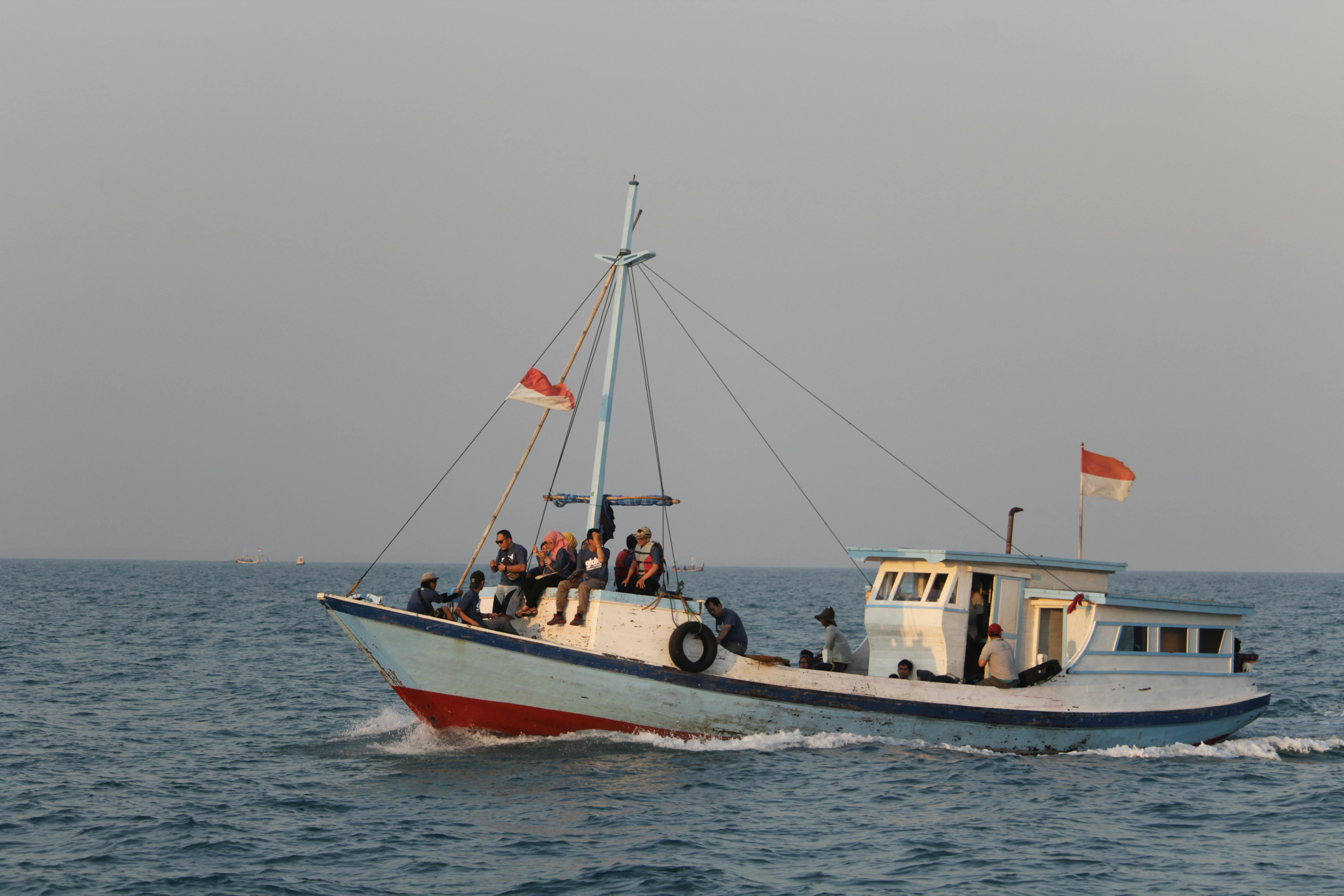 Person Riding Brown Wooden Boat on Body of Water · Free Stock Photo