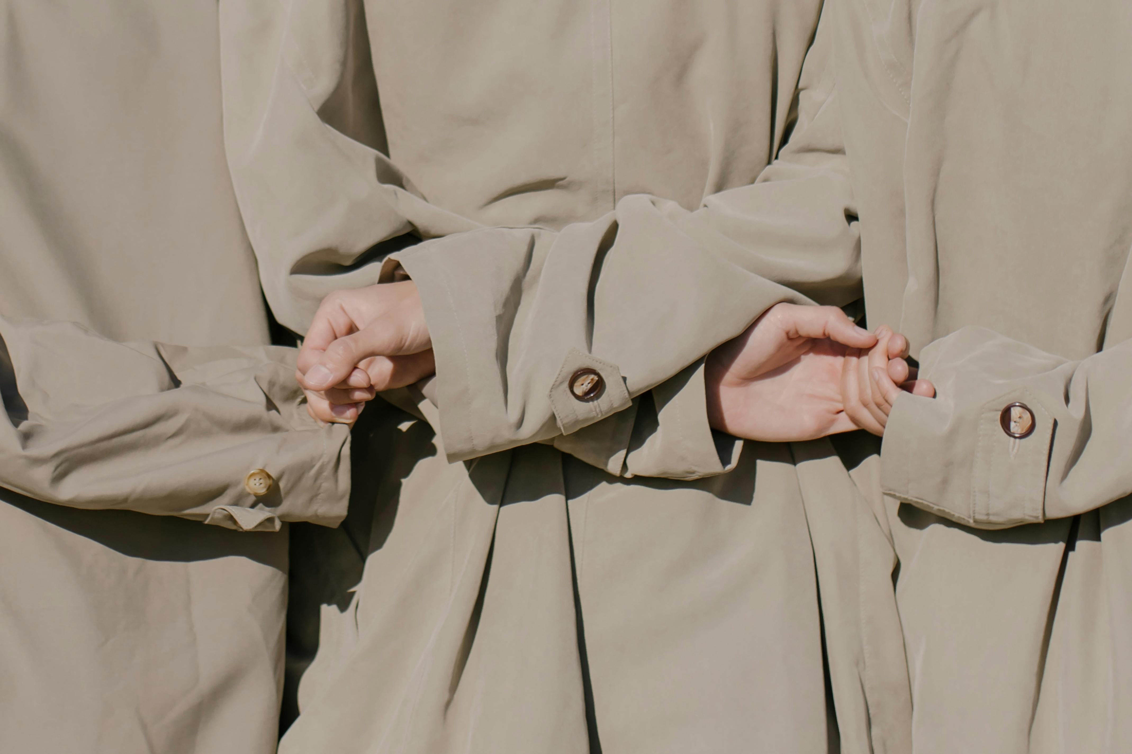Persons Wearing Beige Coats Holding Hands · Free Stock Photo