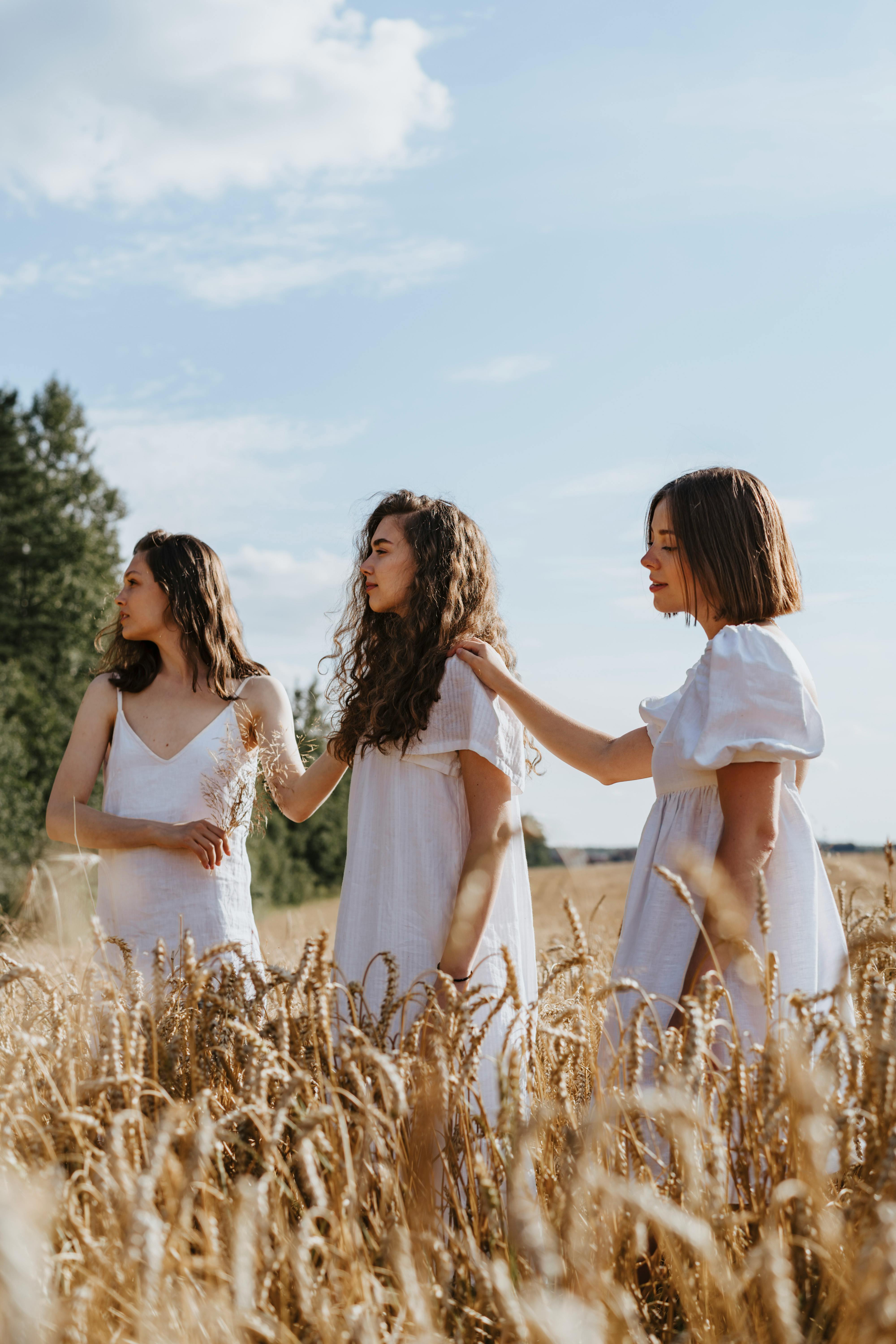 Three Women Standing Together Under Blue Sky · Free Stock Photo