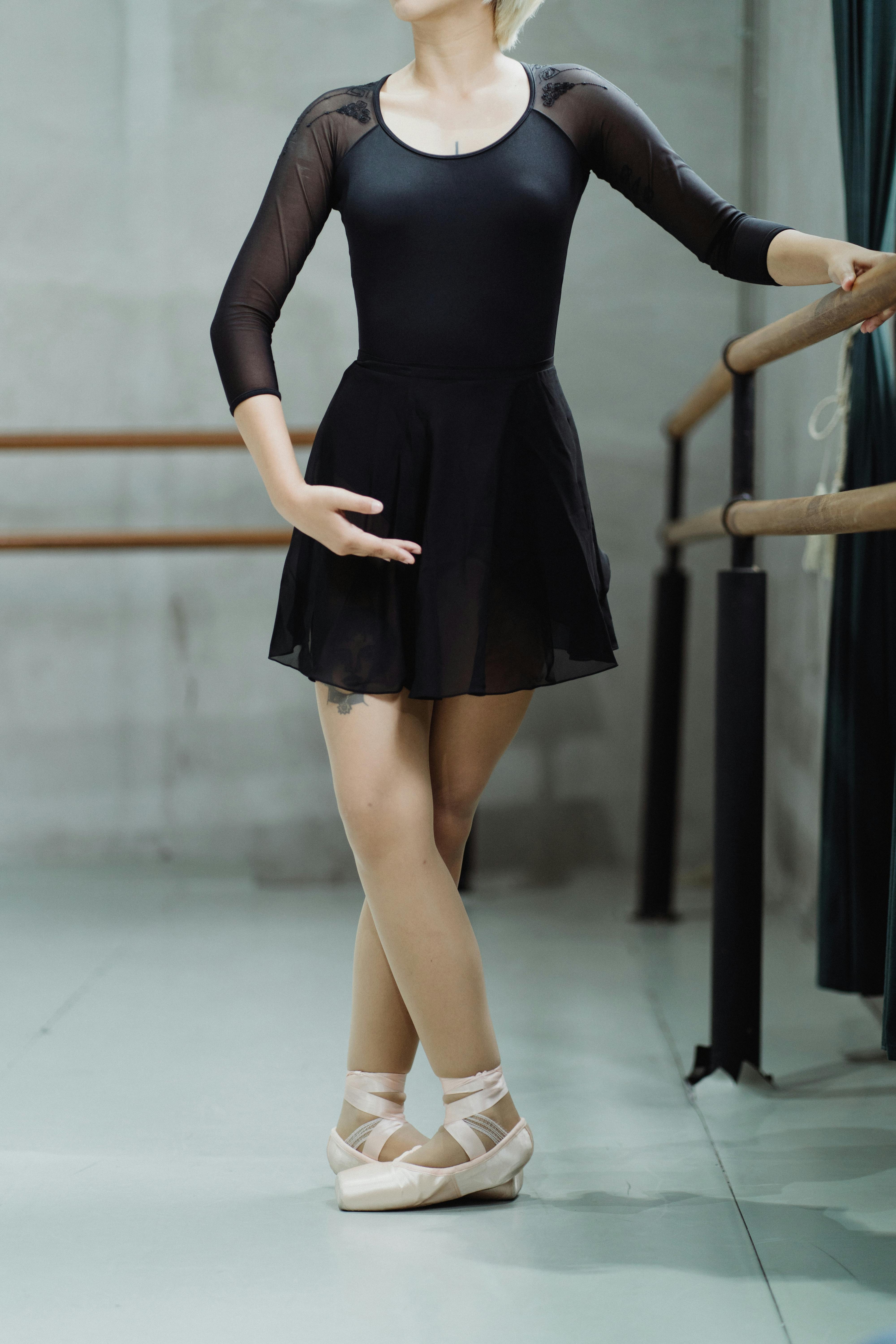 Crop faceless ballerina exercising near rail in studio · Free Stock Photo