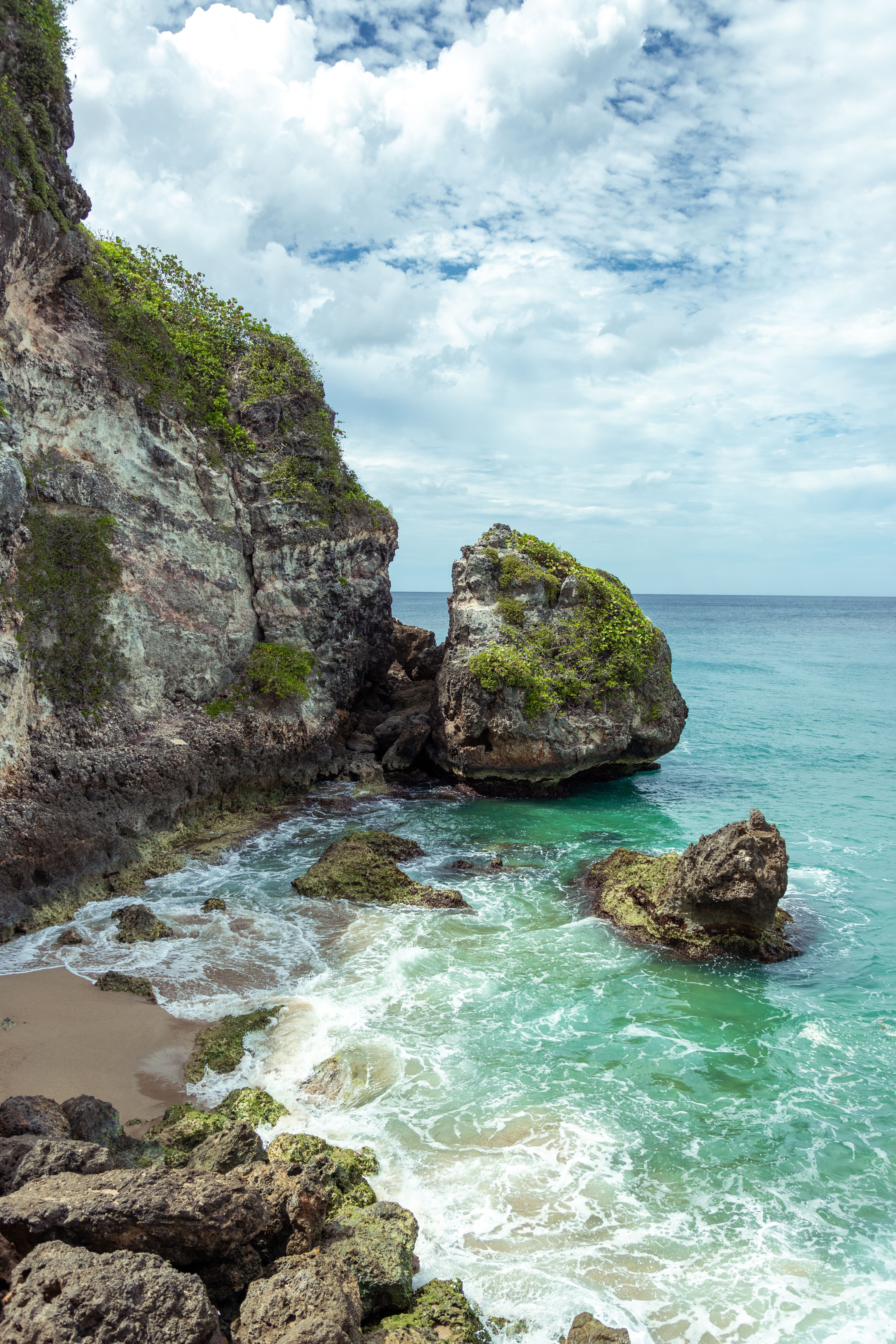 Mossy Rocks Beside a Rock Mountain on Sea · Free Stock Photo