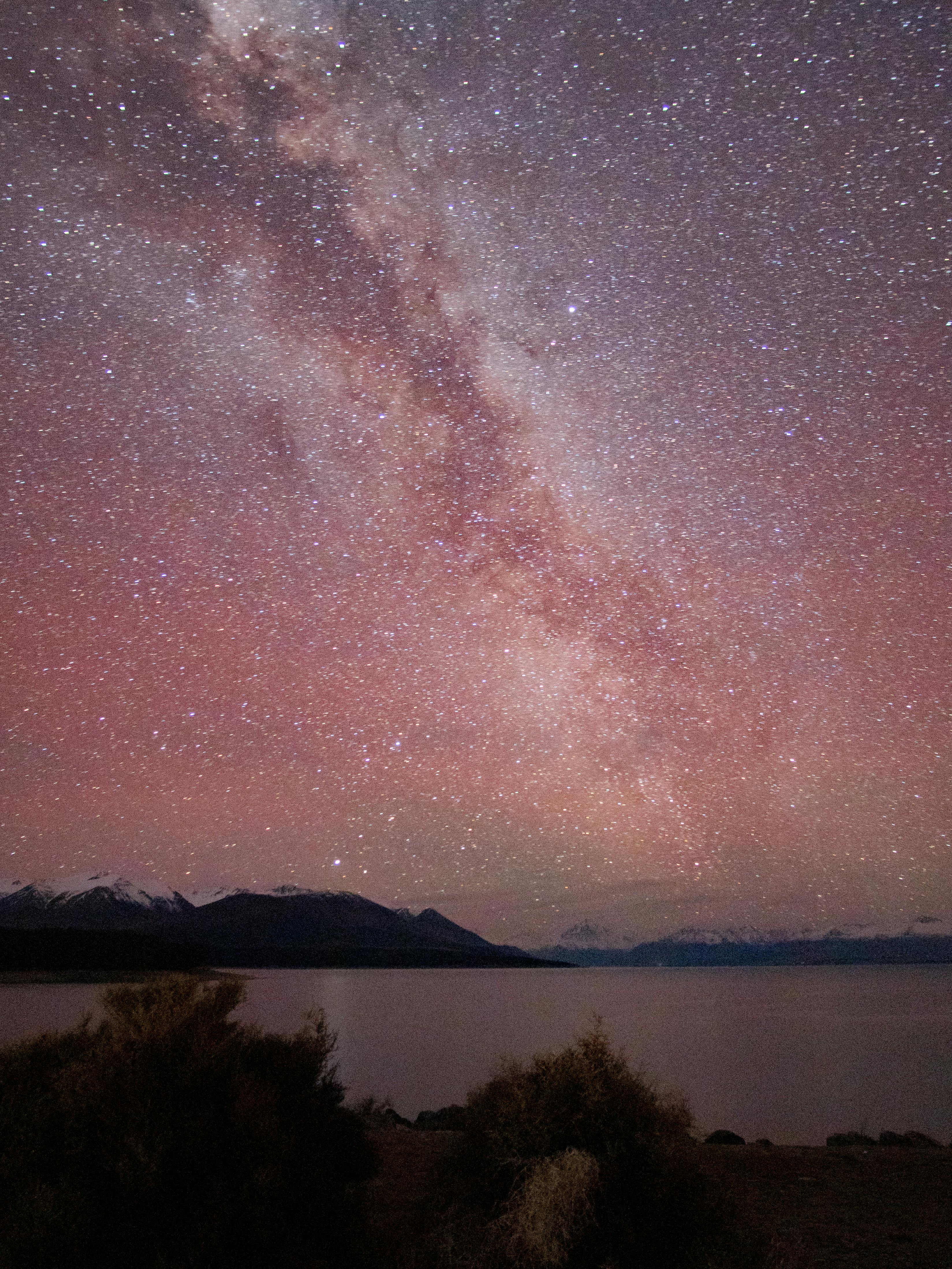 Body of Water Near Mountain Under Starry Night · Free Stock Photo