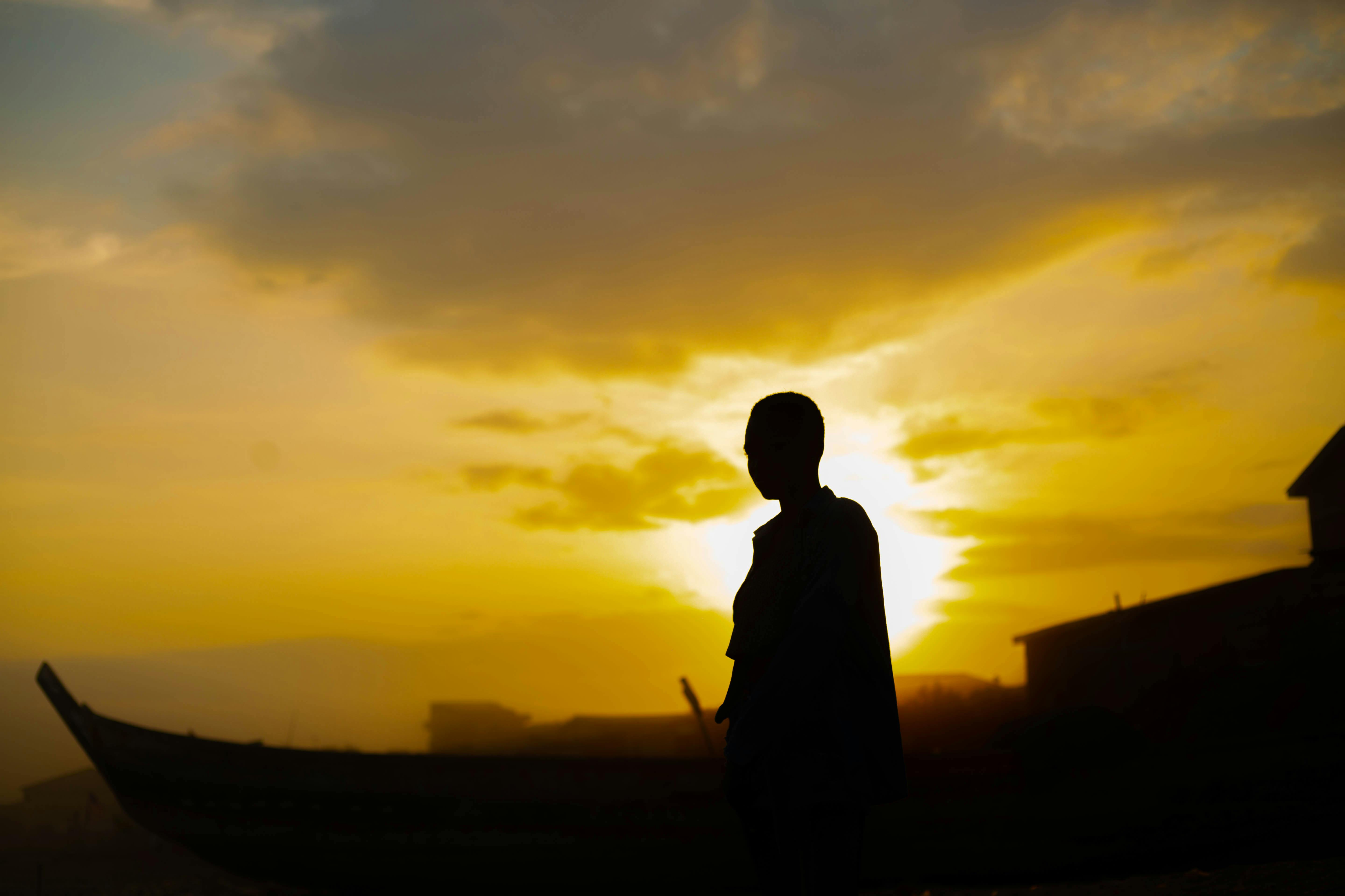 Silhouette of person standing against sunset sky · Free Stock Photo