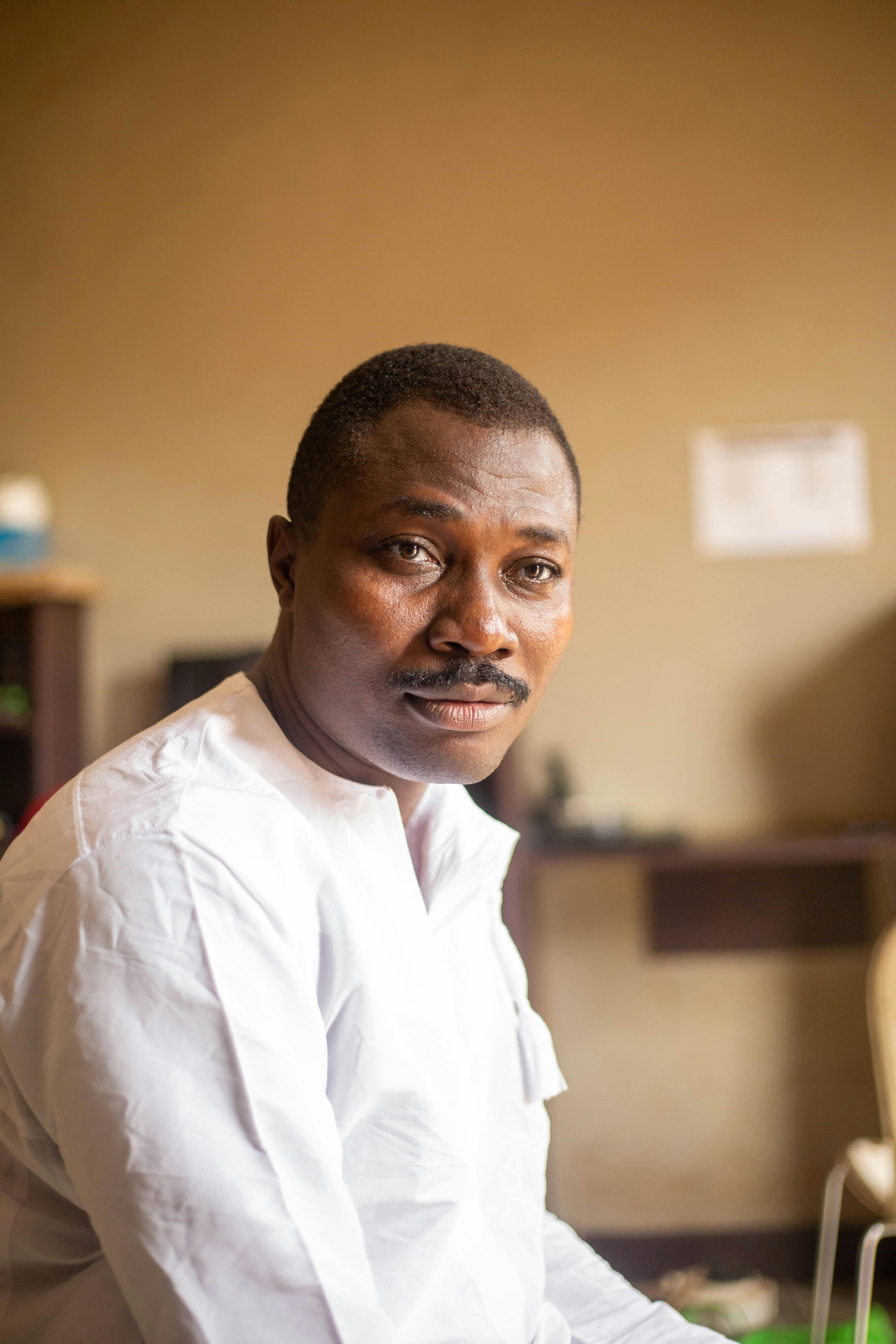 Man standing by chair with head down · Free Stock Photo