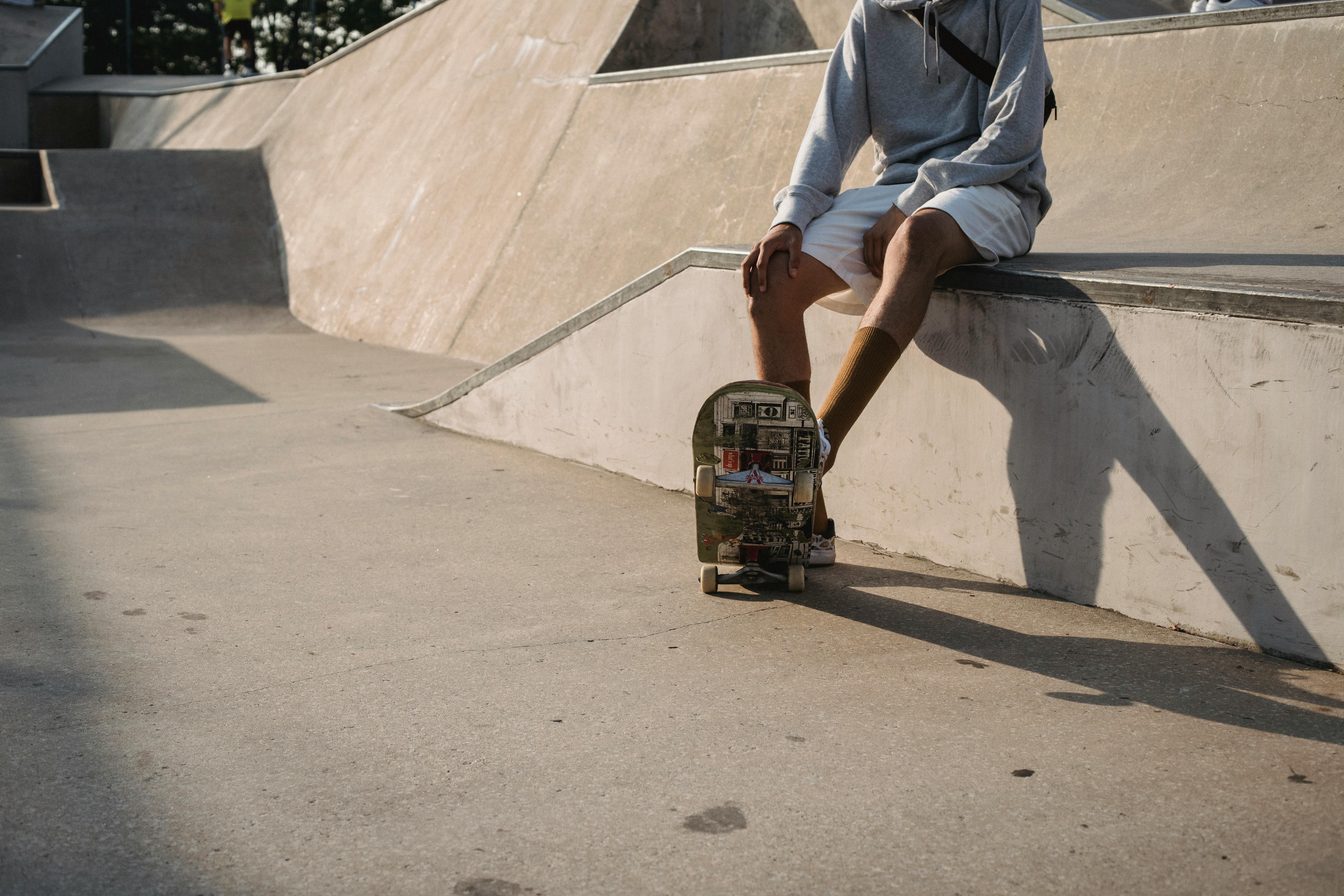 Skateboarder resting on ramp in skate park · Free Stock Photo
