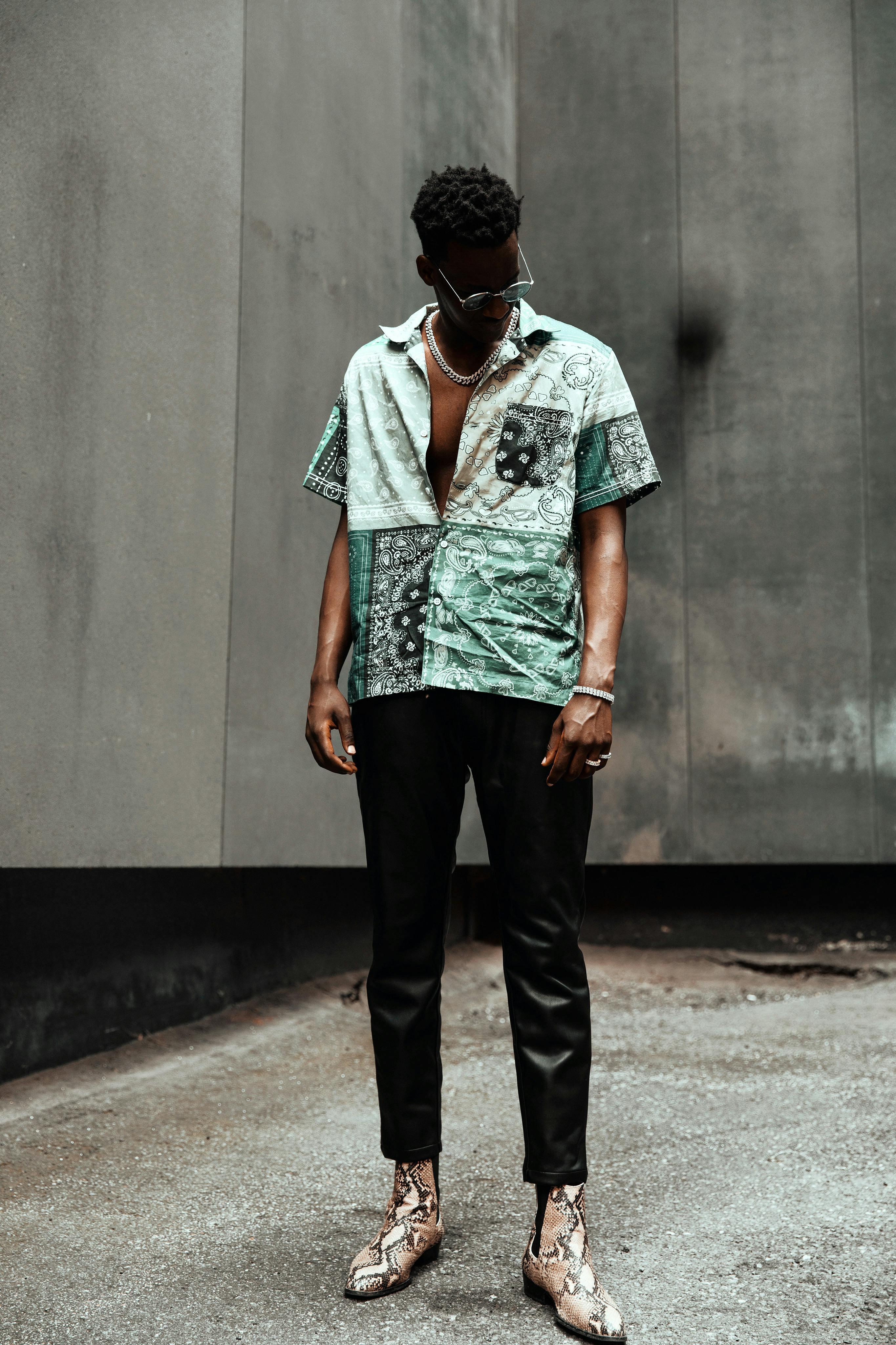 Stylish black man sitting on haunches · Free Stock Photo