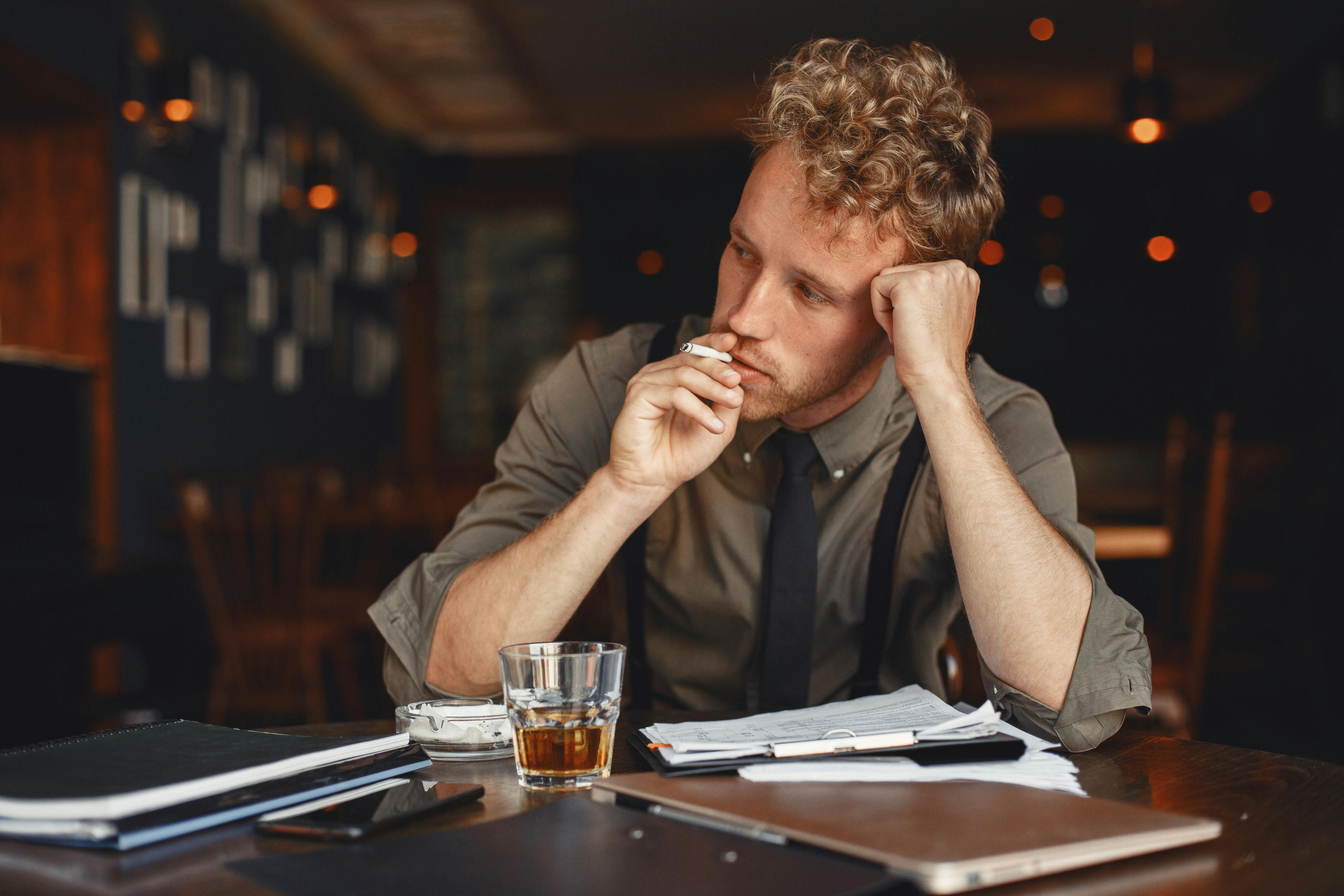 Man Smoking by Table · Free Stock Photo