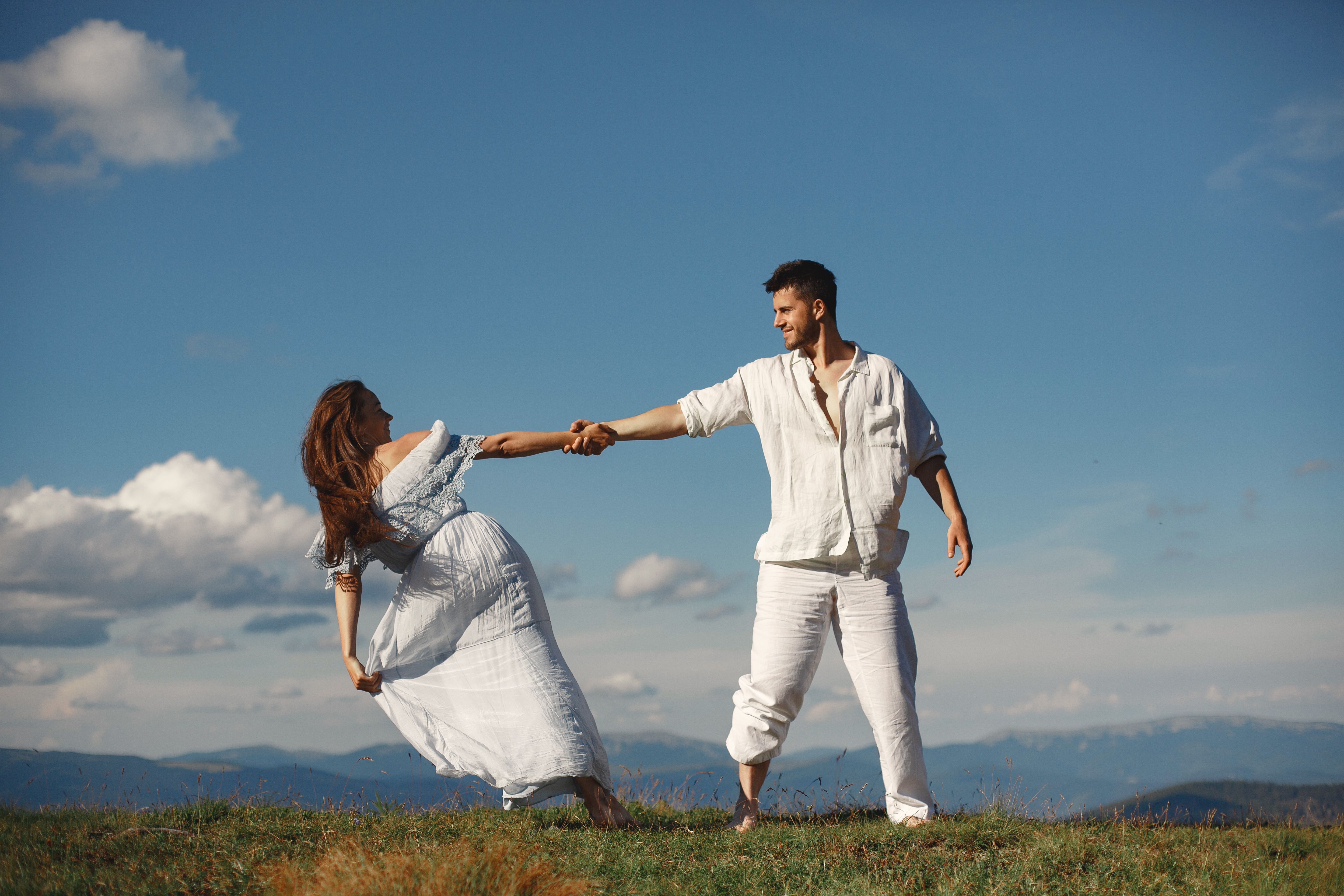 Man and Woman Holding Hands While Dancing on Green Grass Field · Free ...