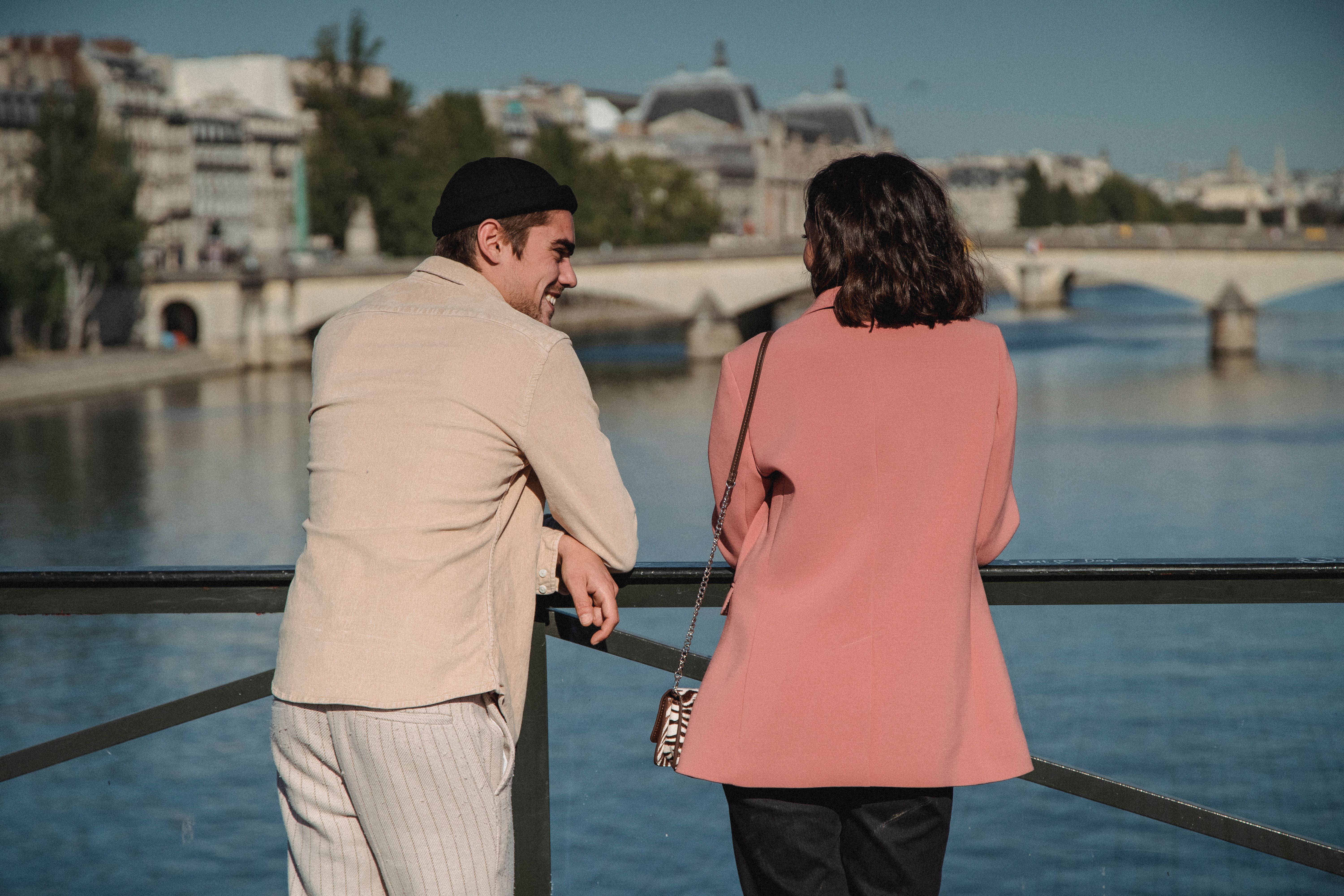 Man and Woman Leaning on Guard Rail · Free Stock Photo