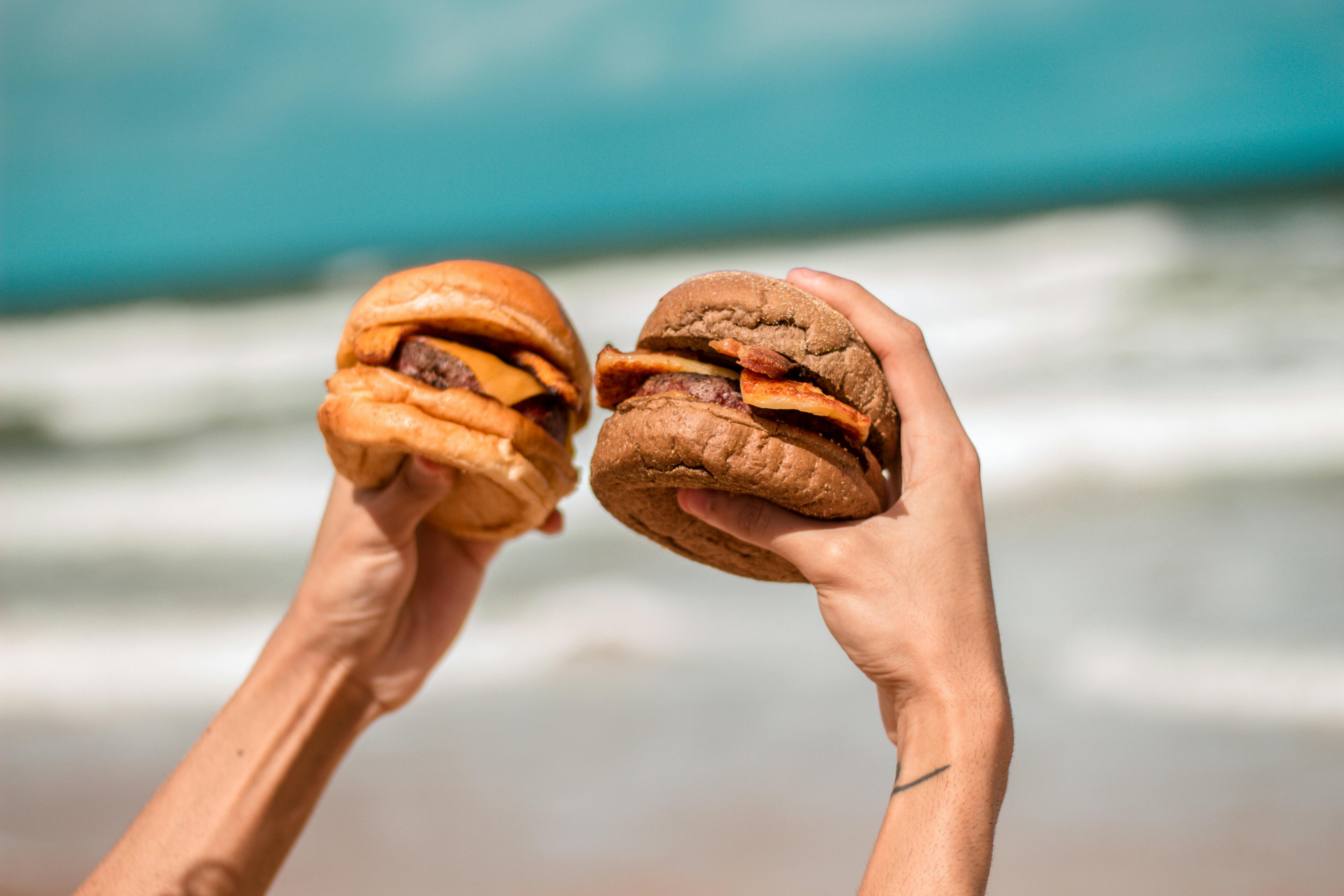 Person Holding Two Burgers · Free Stock Photo