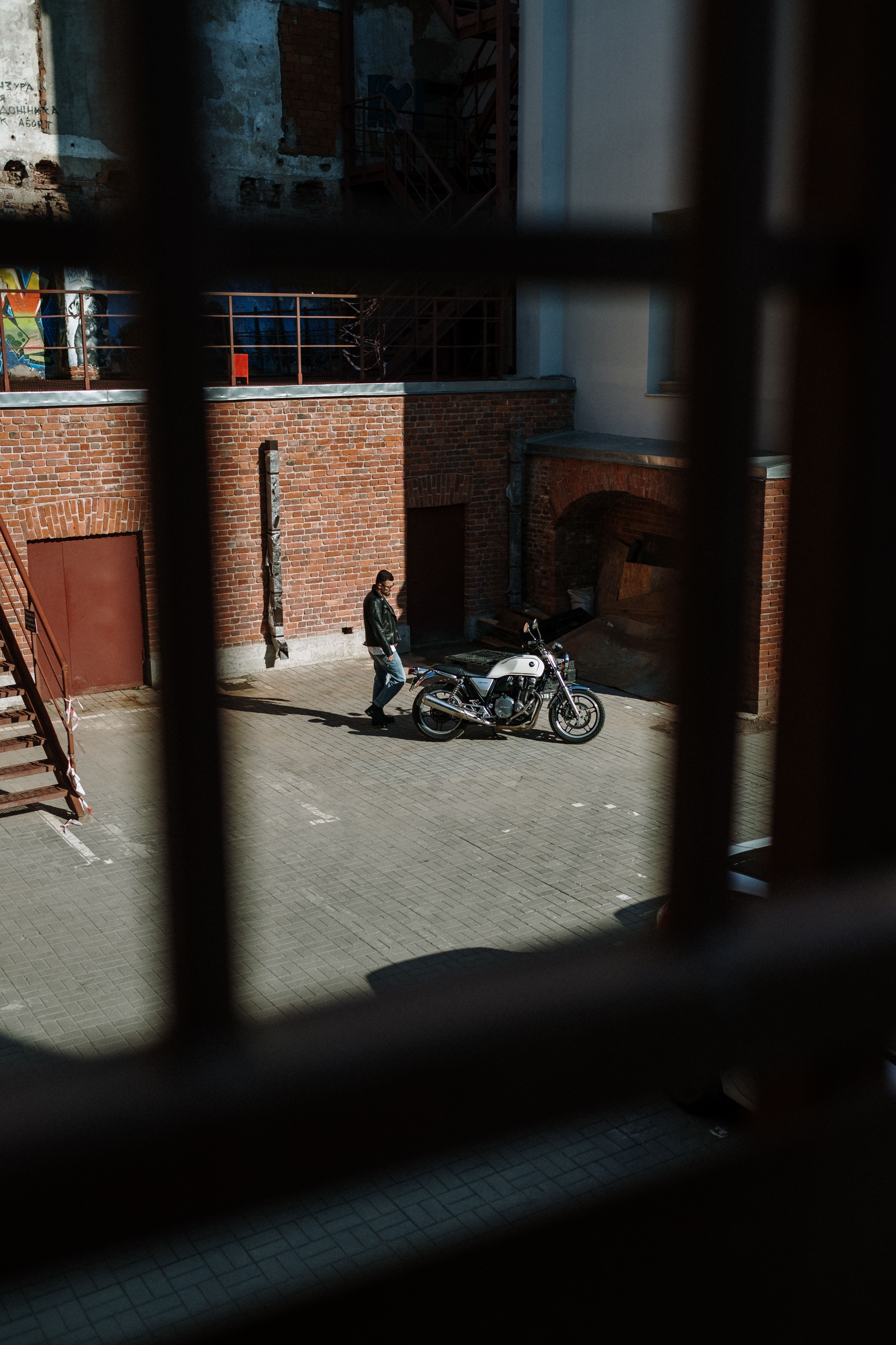 Man Walking towards a Parked Motorcycle · Free Stock Photo