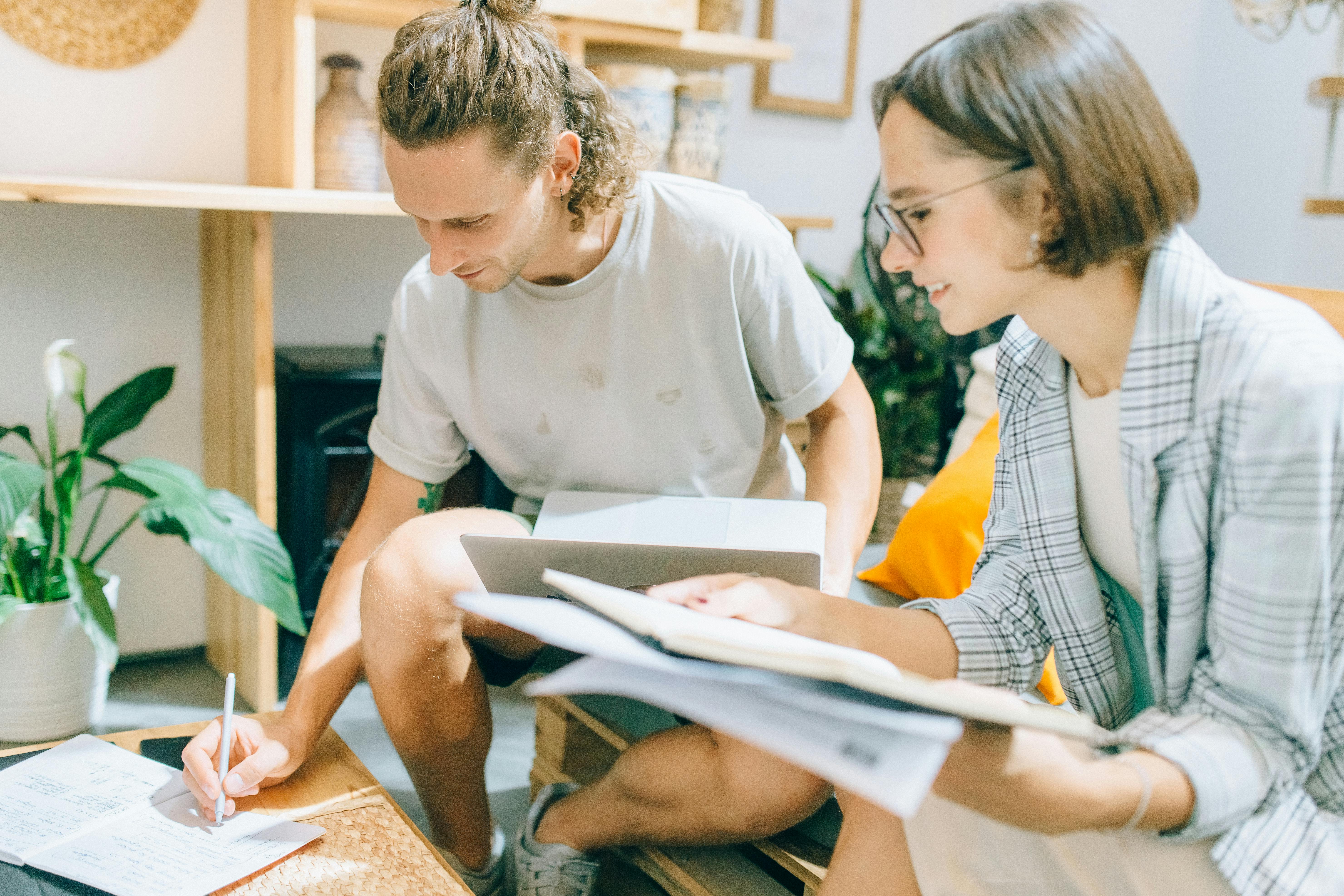 Man Writing and Sitting near Woman in Glasses · Free Stock Photo