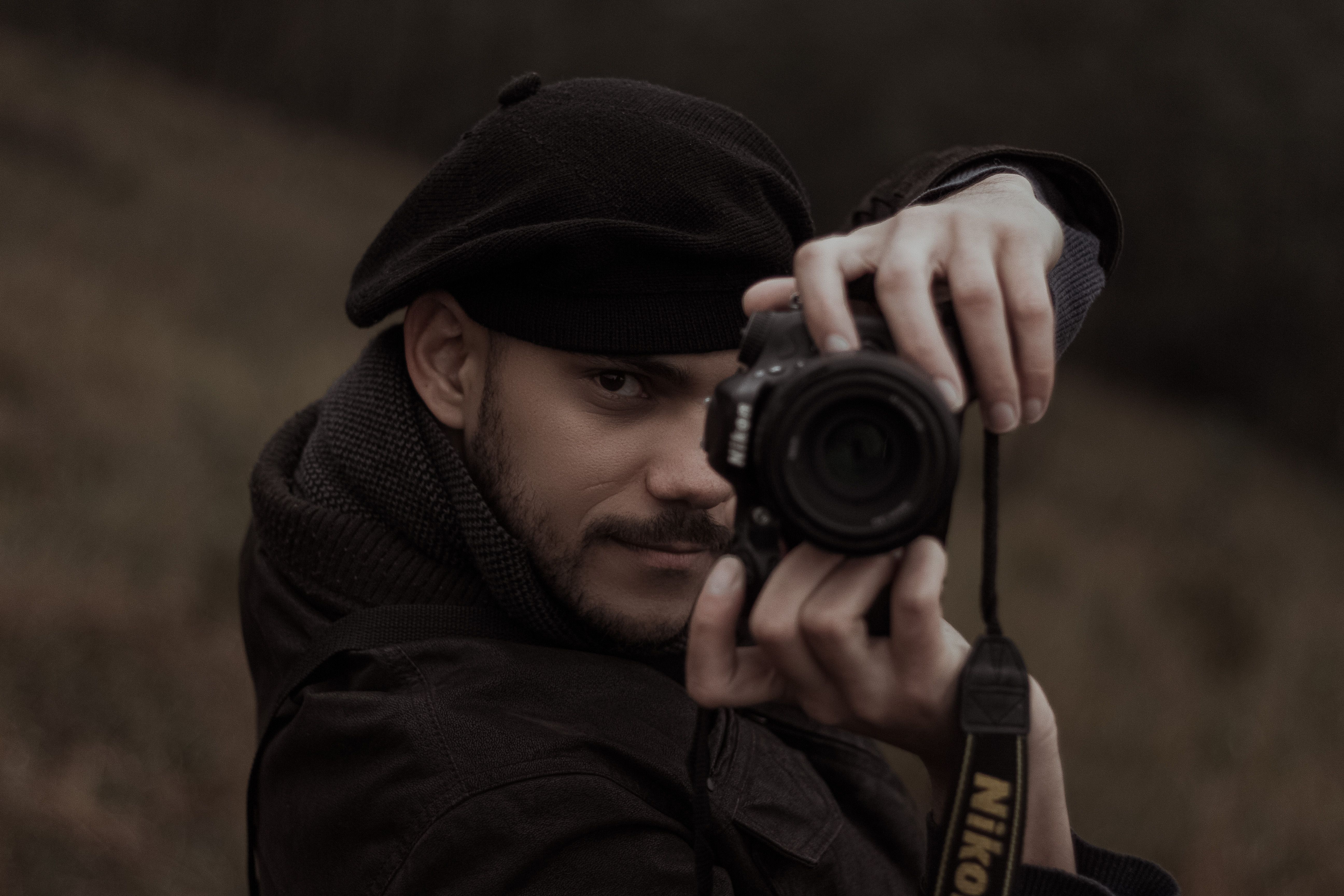 Young man focusing with photo camera and looking at camera · Free Stock ...