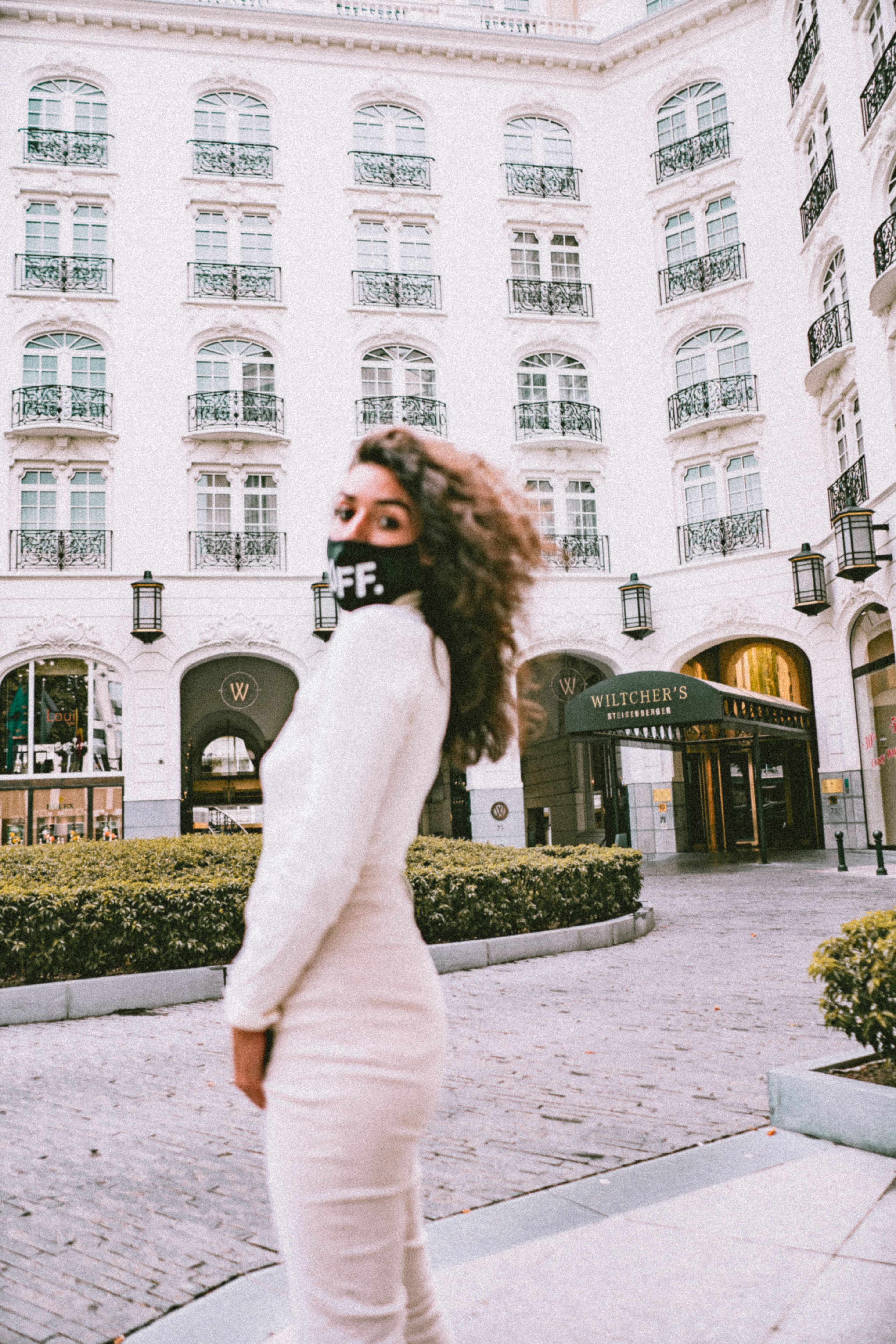 Woman Wearing a Face Mask Standing outside of a Hotel · Free Stock Photo