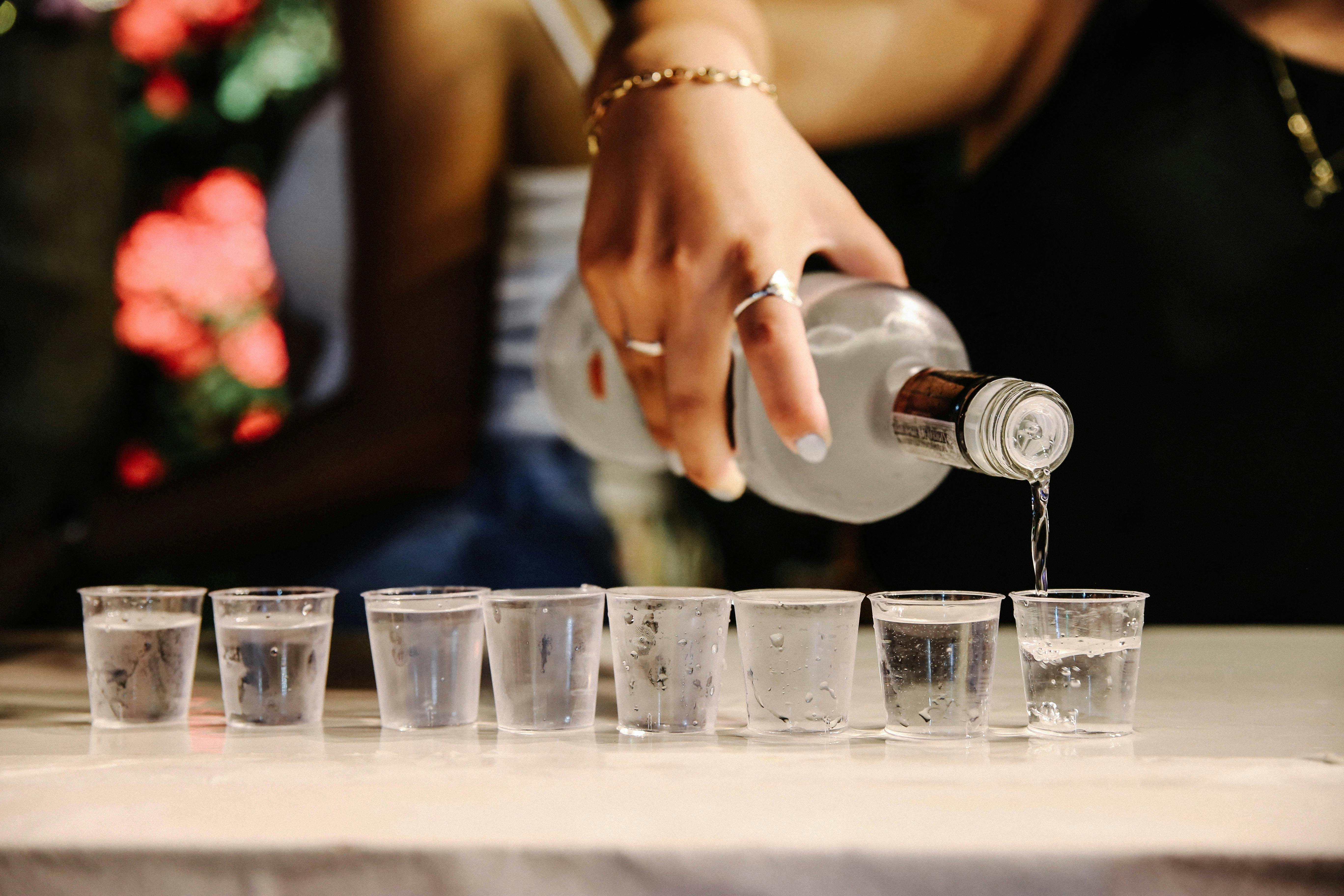 Close-up of Bottle Pouring Water on Glass · Free Stock Photo